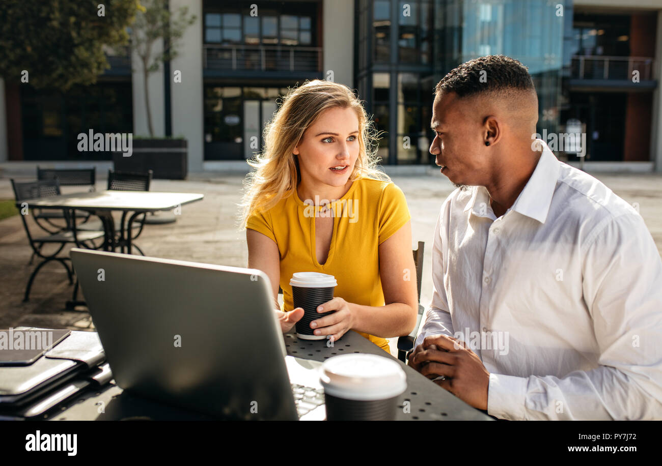 Two business people talking while sitting at office cafeteria. business ...