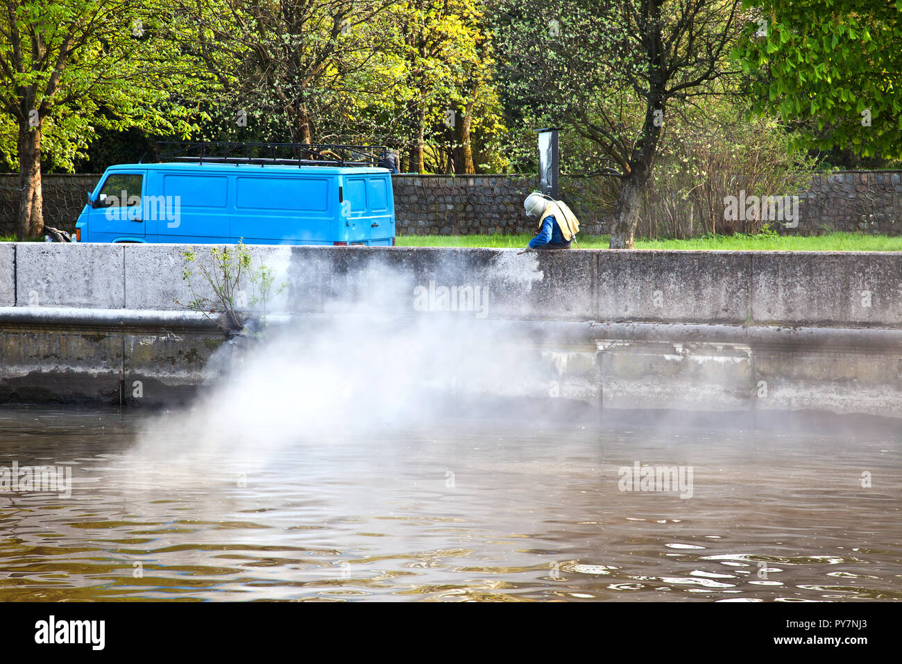 Worker removes dirt from the parapet on the embankment of the Pregolya ...