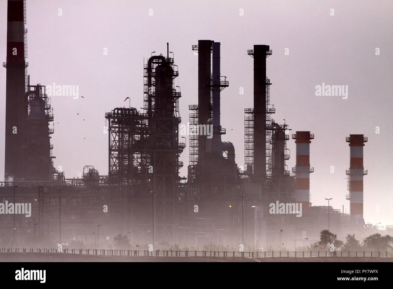 Silhouette of part of a big oil refinery with interesting light seeing ...