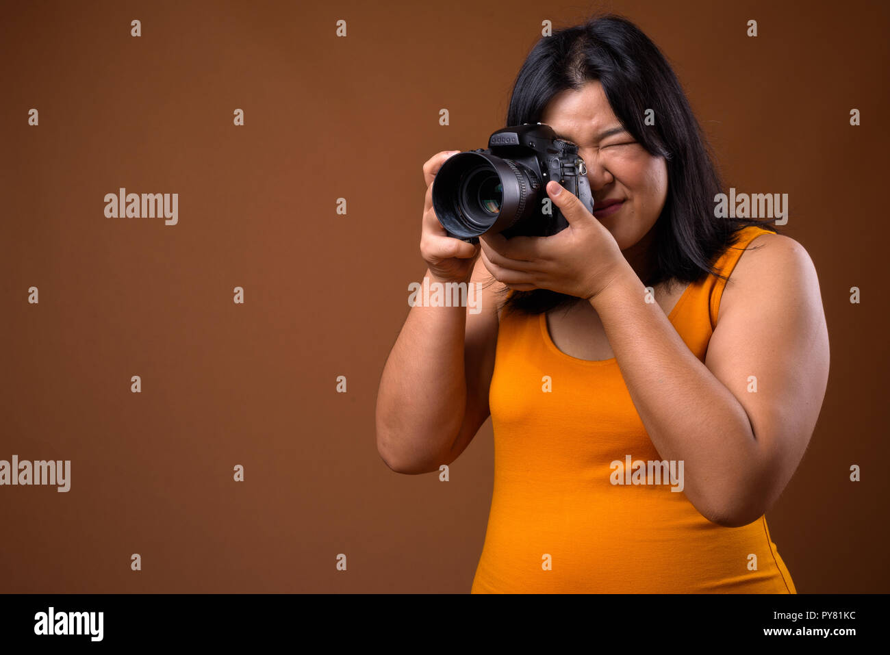Beautiful overweight Asian woman photographer using camera Stock Photo ...