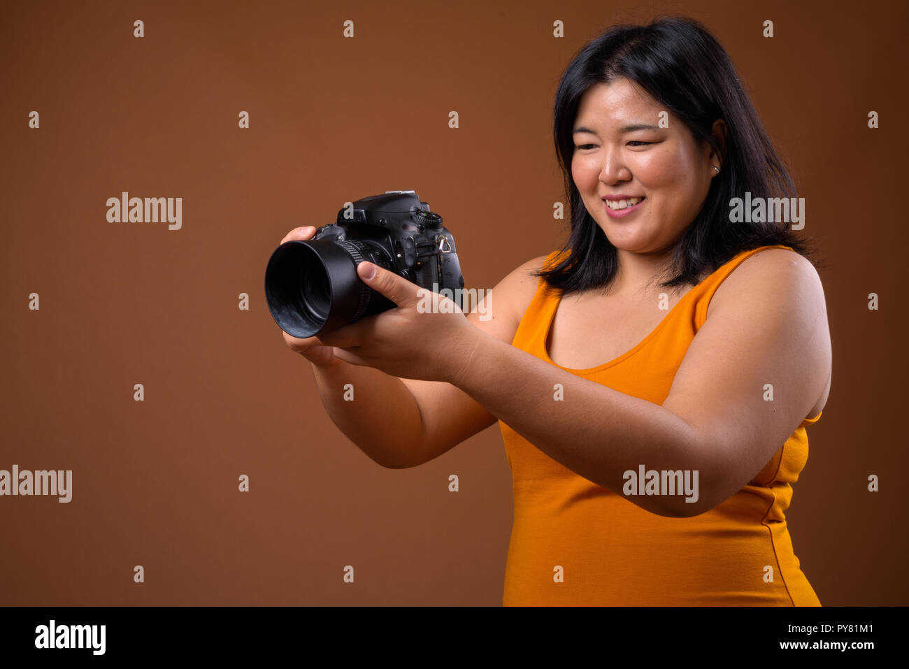 Beautiful overweight Asian woman photographer using camera Stock Photo ...