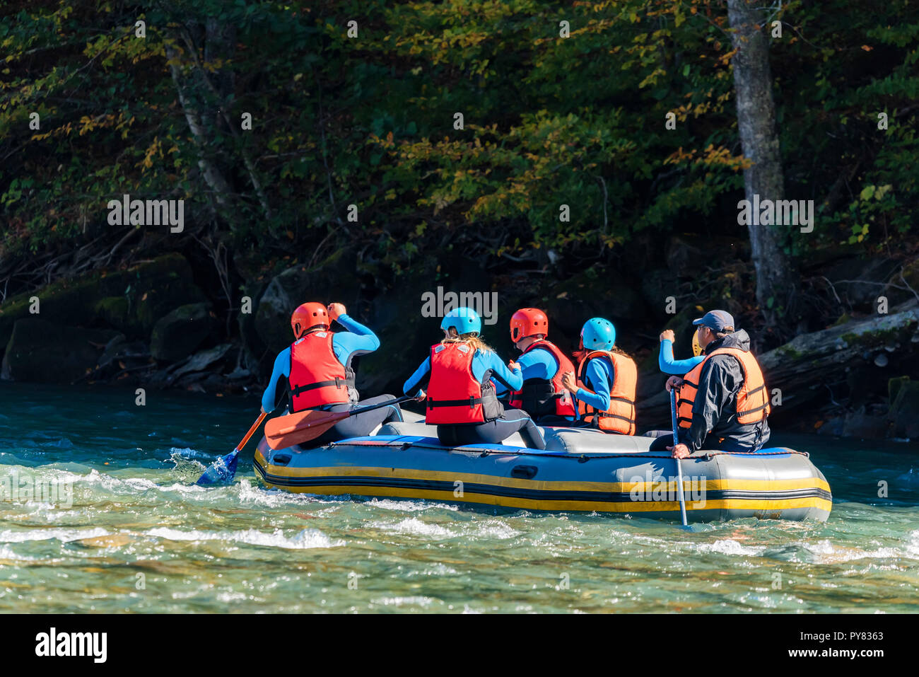 Group of young people going white water rafting Stock Photo - Alamy