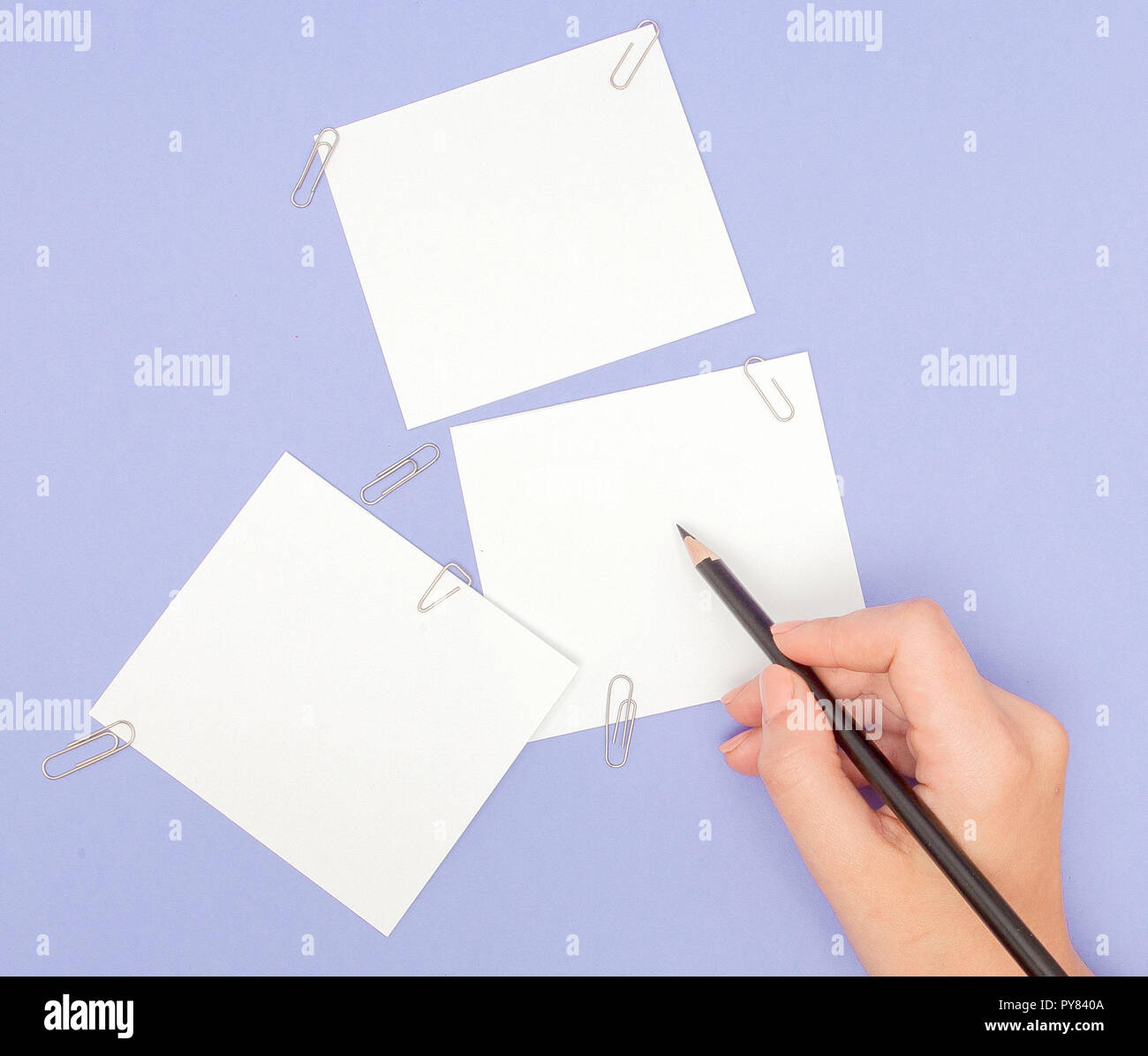 Womens hand writing on note papers on purple background. Blanks sheet ...