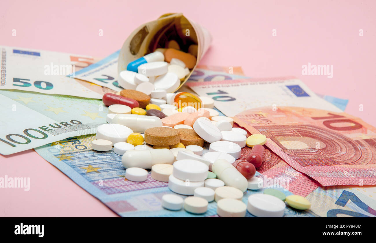 The tablets wrapped in euro with euro banknotes on a pink background ...
