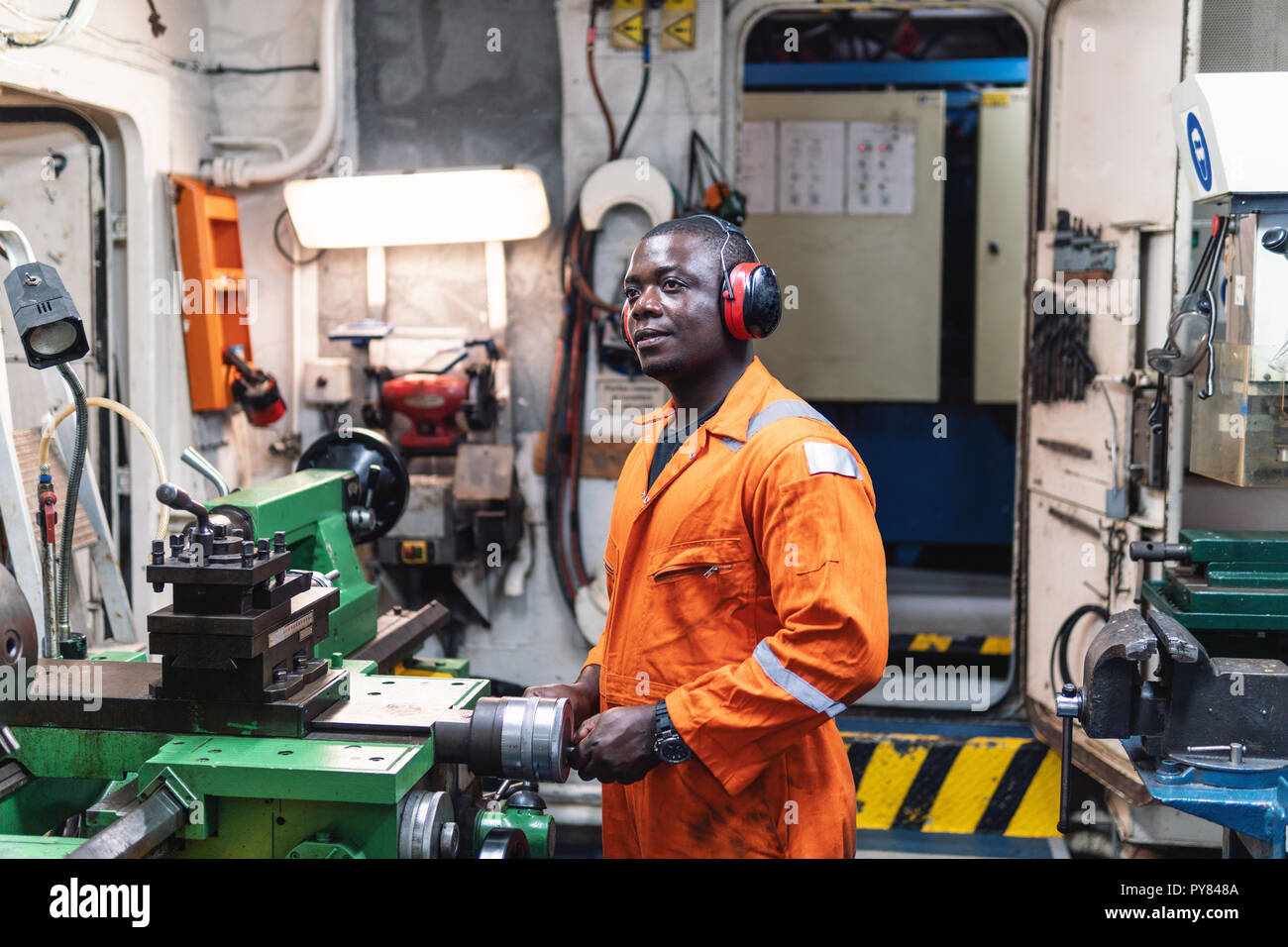 Marine engineer officer working in engine room Stock Photo - Alamy