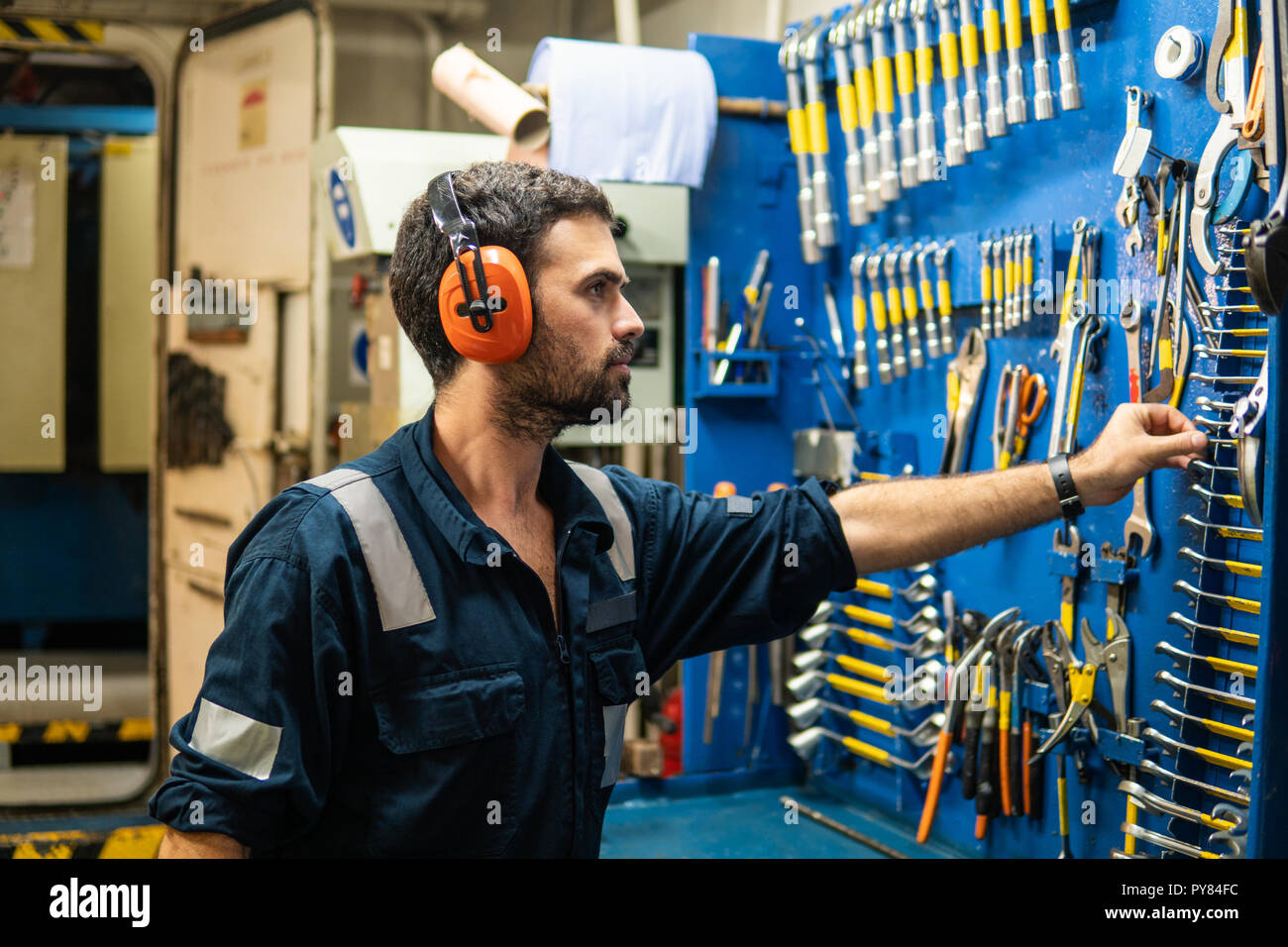 Marine engineer officer working in engine room Stock Photo - Alamy
