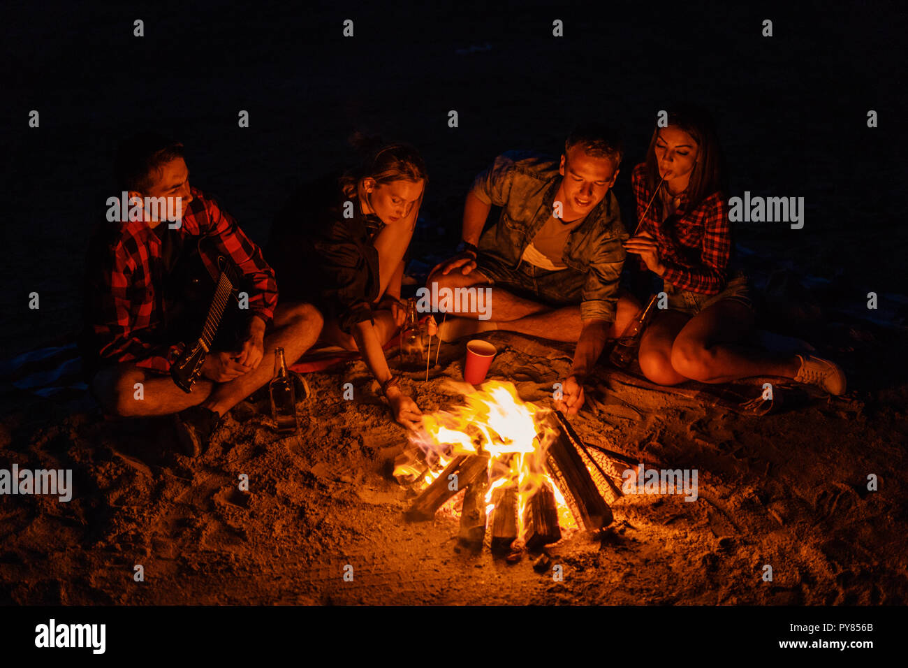 young couples have picnic with bonfire on the beach Stock Photo - Alamy