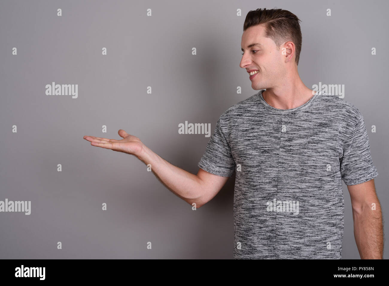 Young handsome man showing copy space and presenting Stock Photo - Alamy