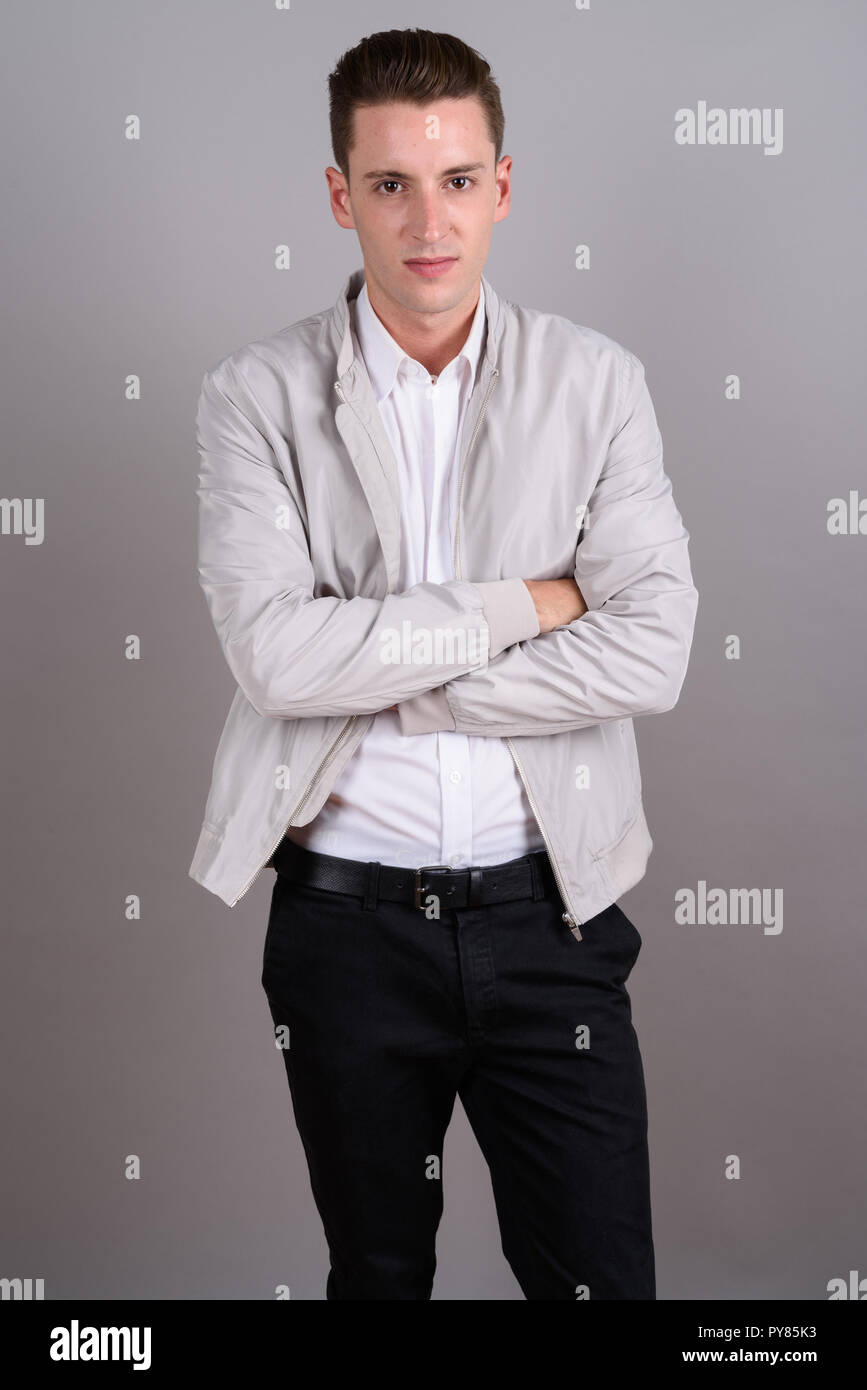 Young handsome man wearing jacket with arms crossed Stock Photo - Alamy