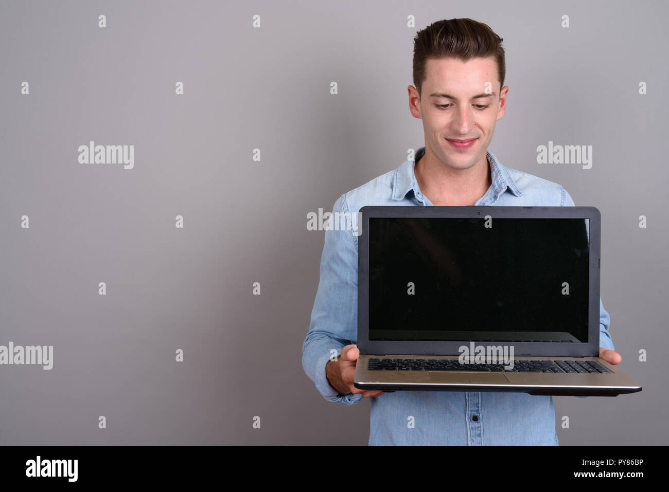 Man holding and showing copy space from laptop computer Stock Photo - Alamy