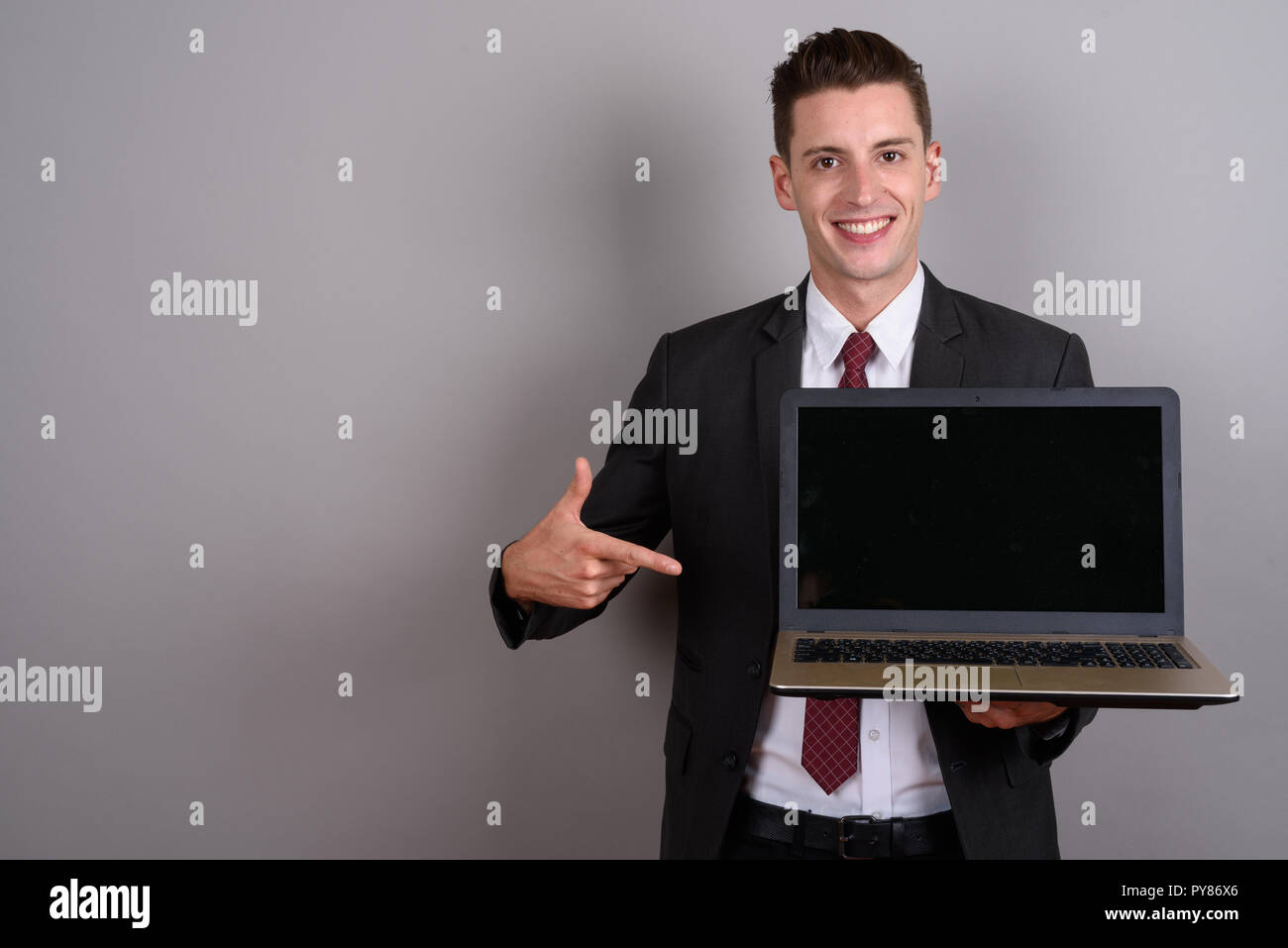 Young happy businessman holding laptop computer with copy space Stock ...