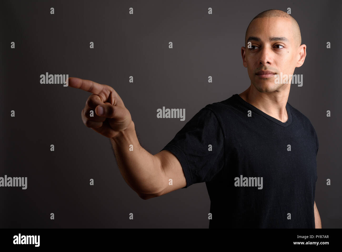 Handsome bald man wearing black shirt and pointing finger Stock Photo ...