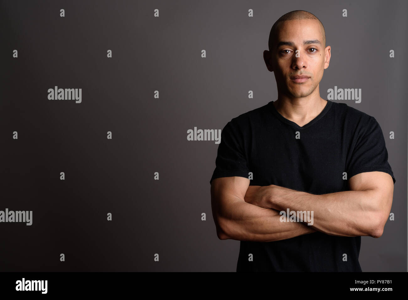 Handsome bald man wearing black shirt with arms crossed Stock Photo - Alamy