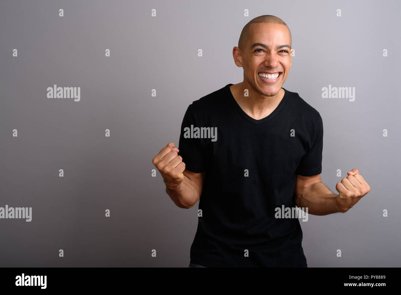 Handsome happy bald man smiling with both arms raised Stock Photo - Alamy