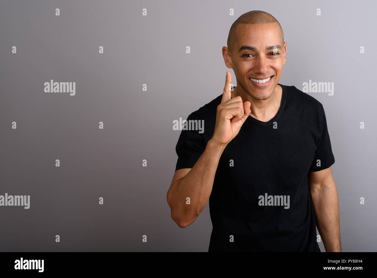 Handsome bald man smiling and pointing finger up Stock Photo - Alamy