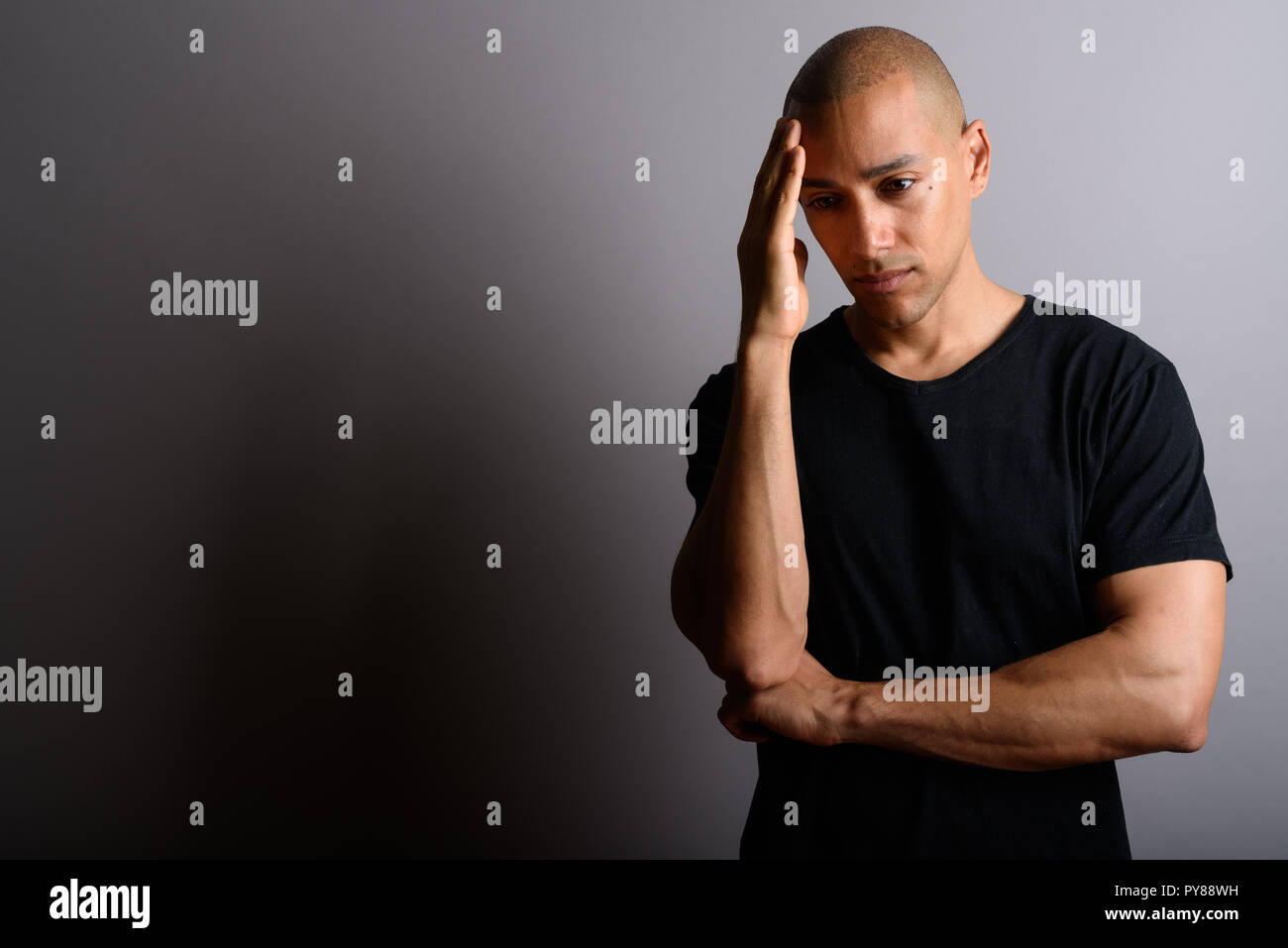 Stressed handsome bald man looking worried while thinking Stock Photo ...