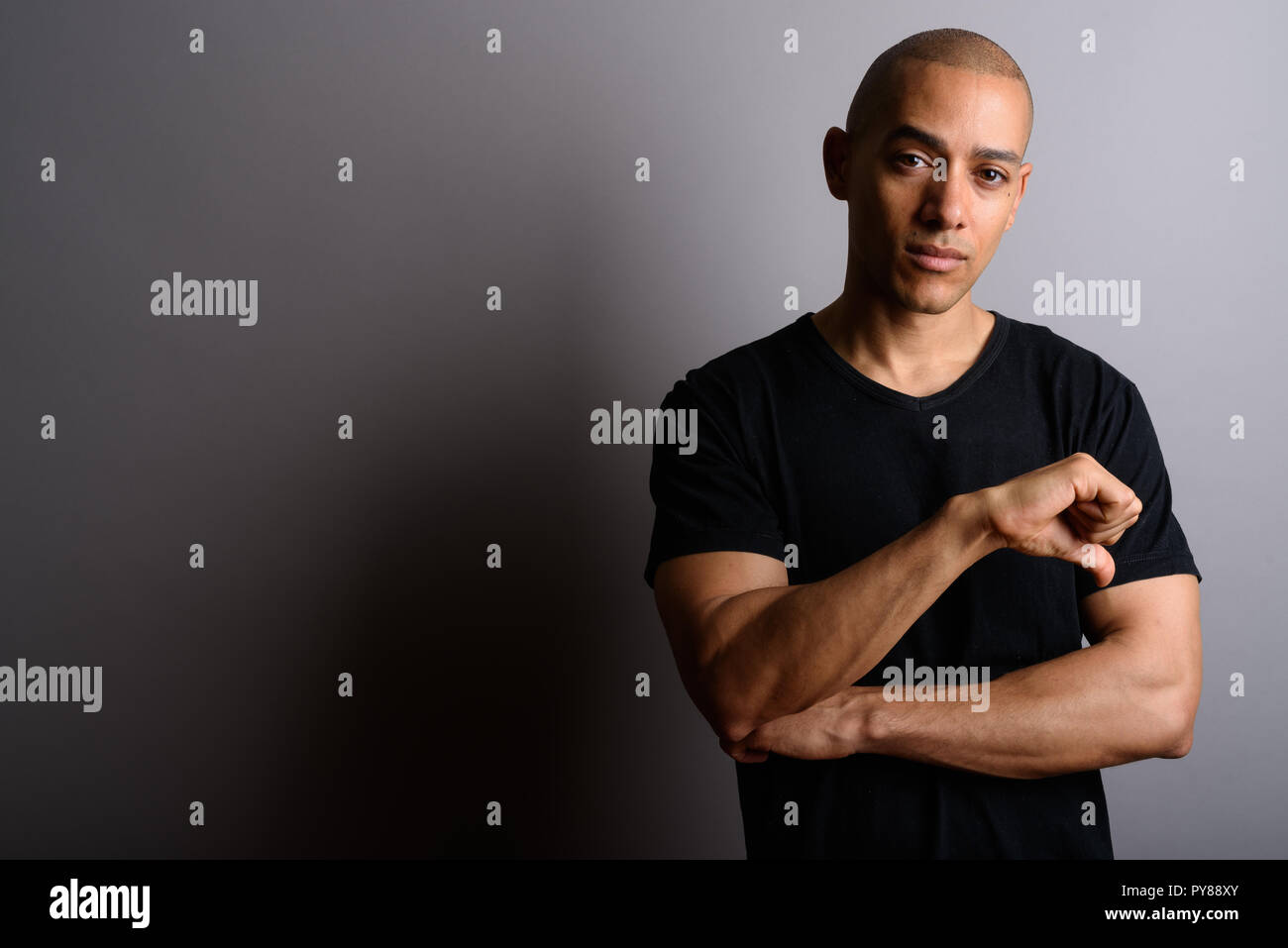 Handsome bald man giving thumb down against gray background Stock Photo ...