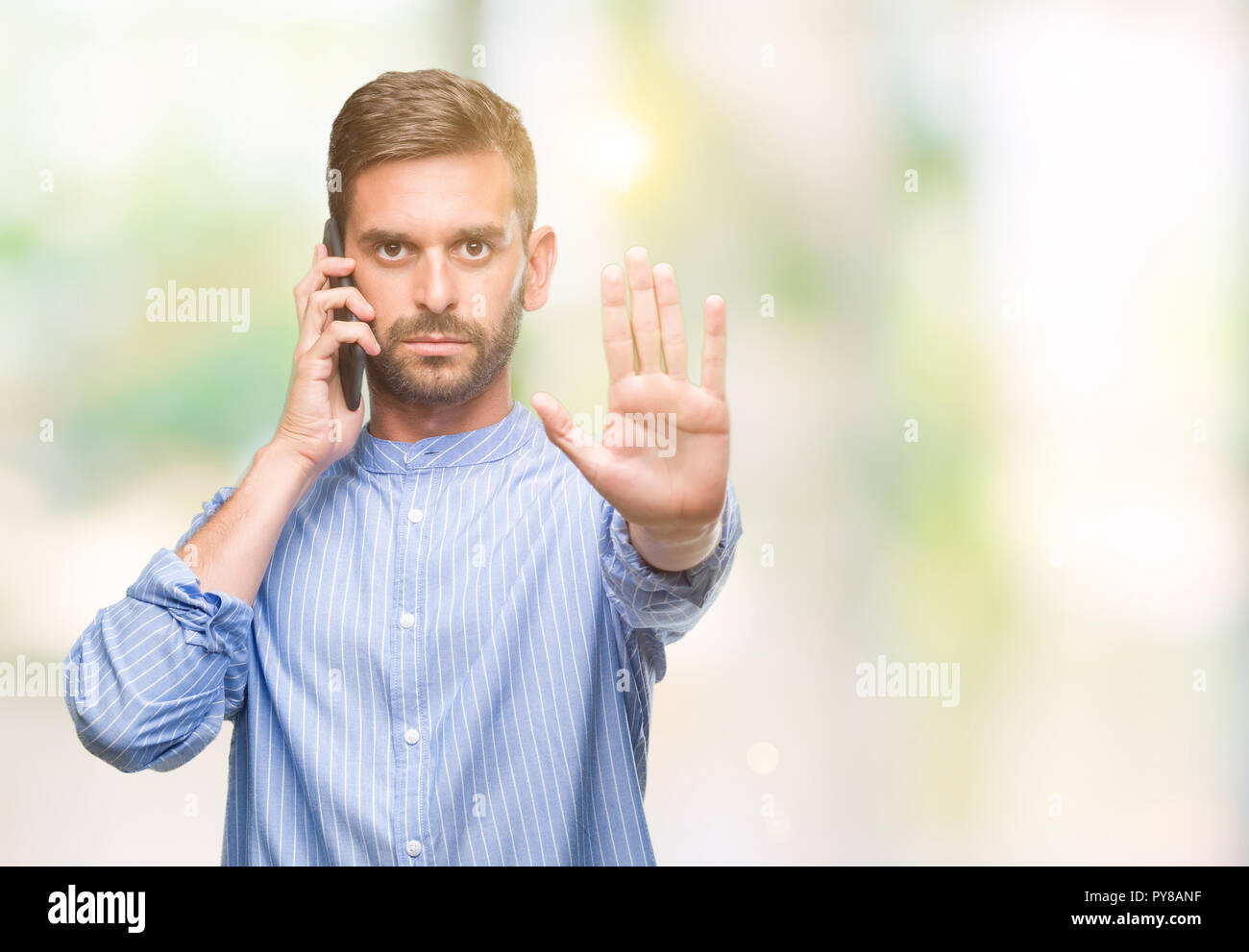 Young handsome man speaking on the phone over isolated background with ...
