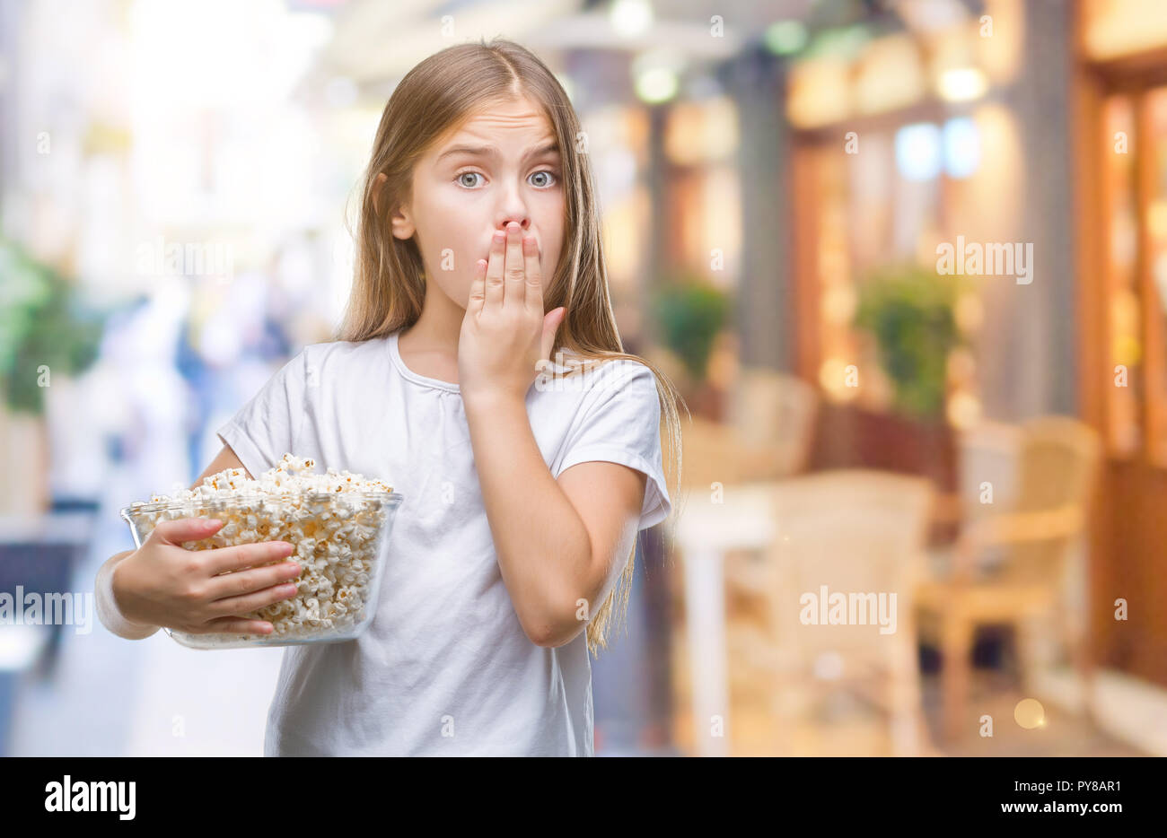 Young beautiful girl eating popcorn snack isolated background cover ...
