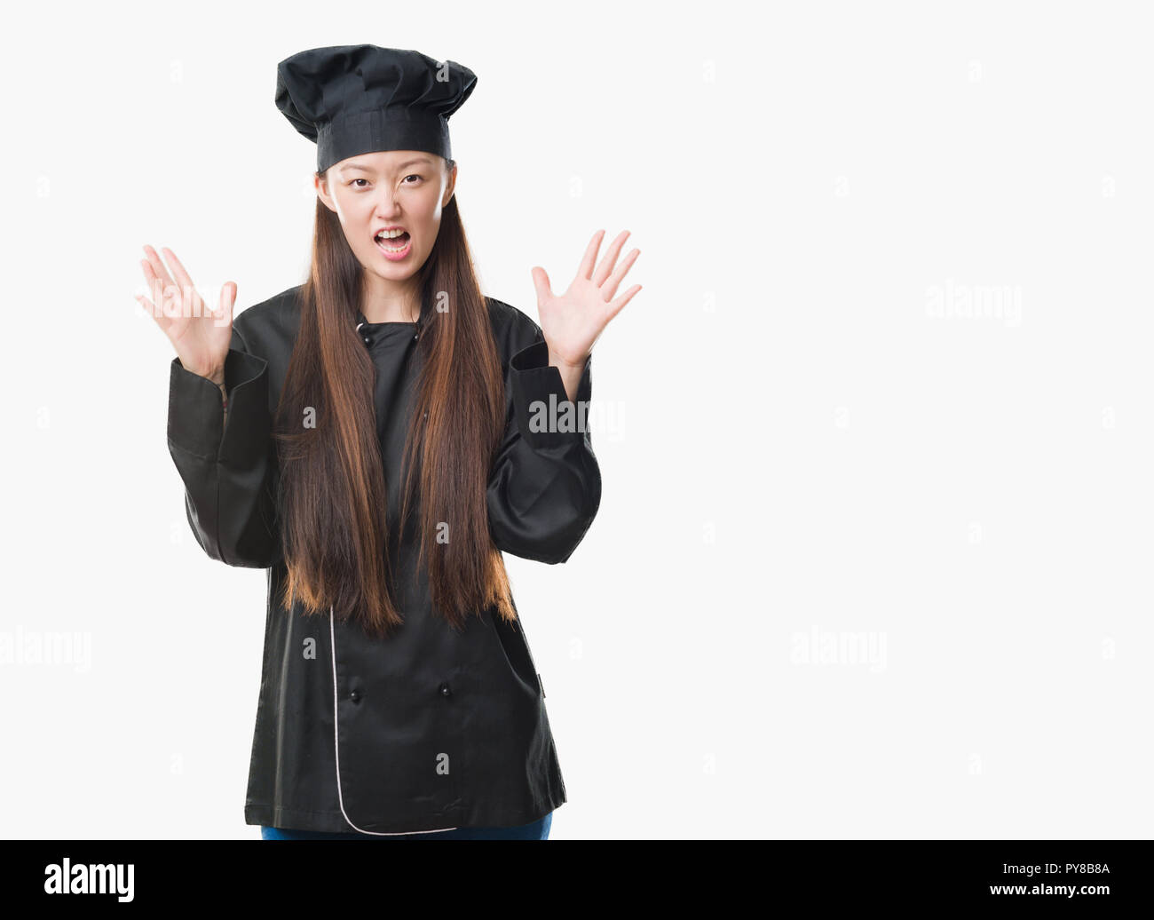 Young Chinese woman over isolated background wearing chef uniform crazy ...