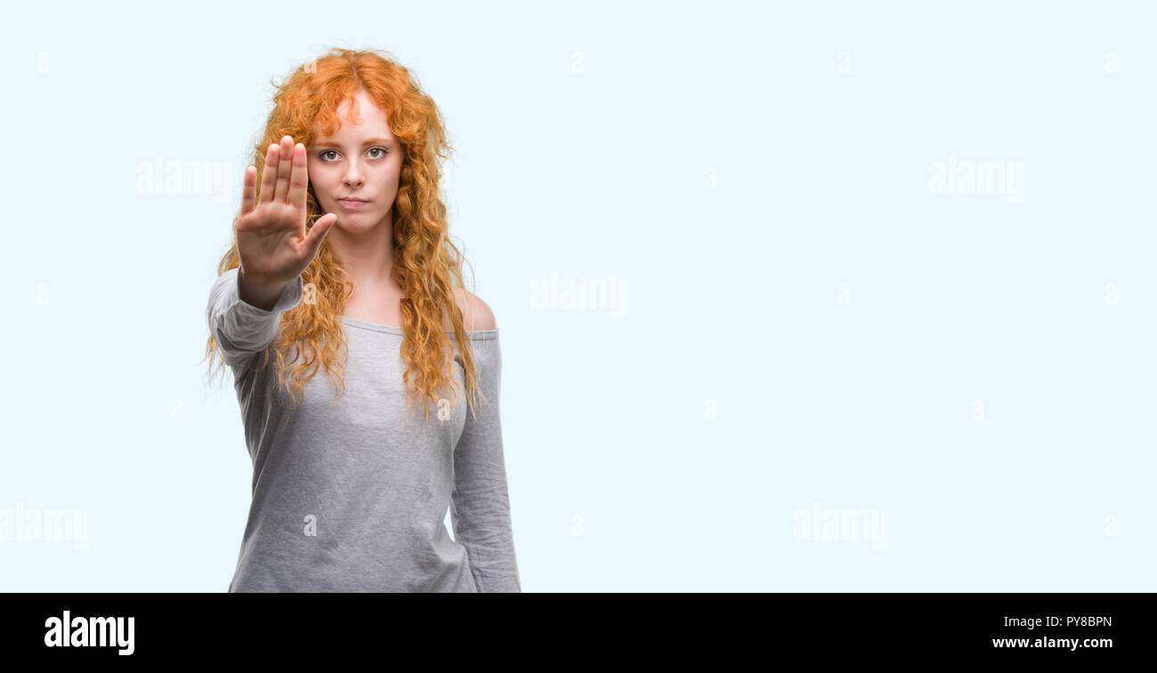 Young redhead woman doing stop sing with palm of the hand. Warning ...