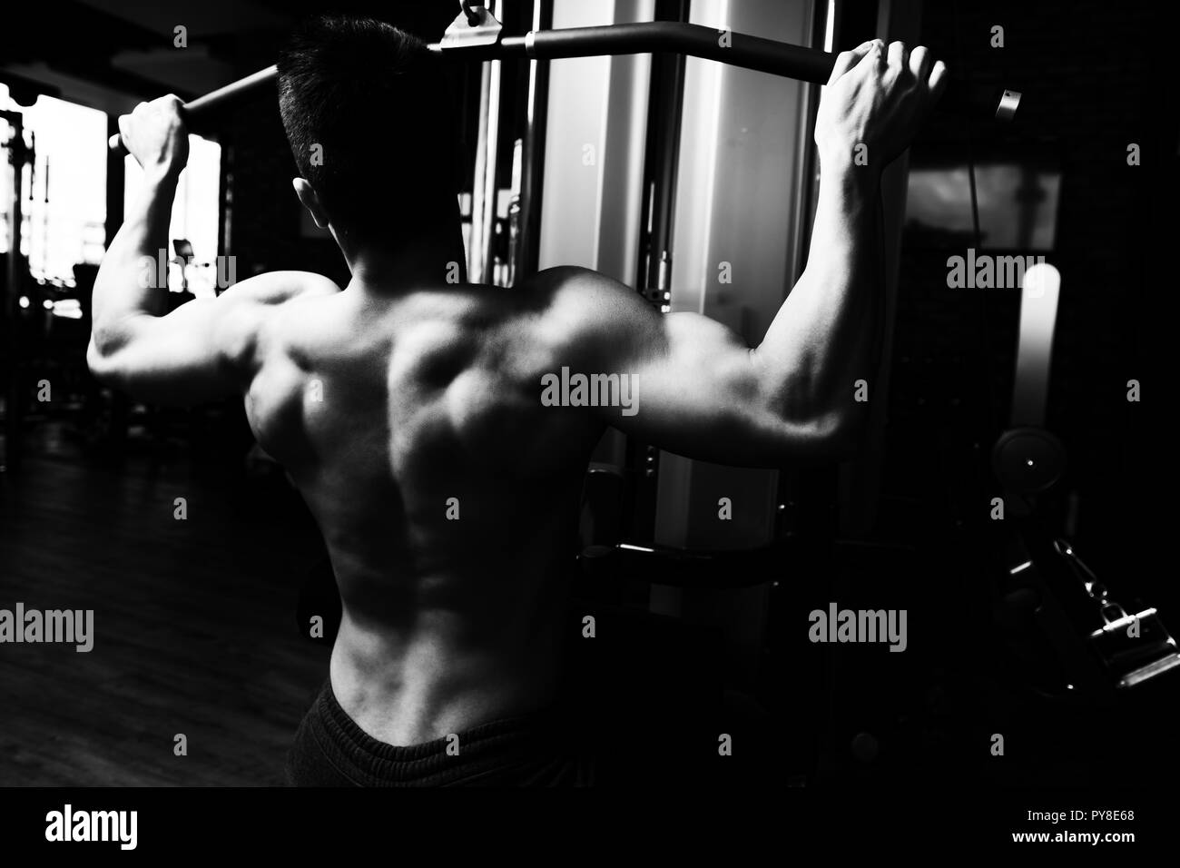 Handsome Bodybuilder Doing Heavy Weight Exercise For Back On Machine ...
