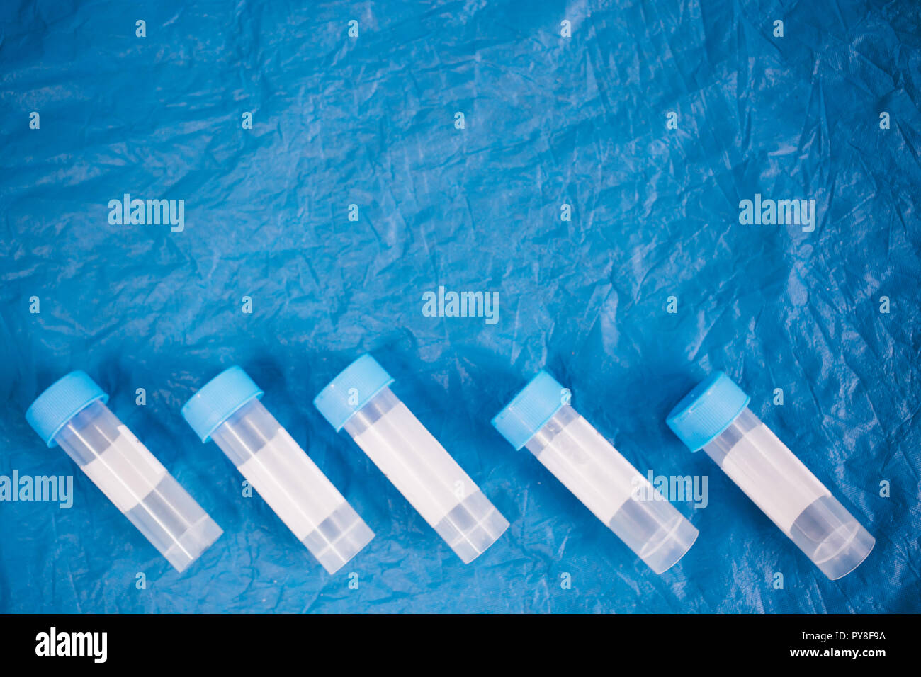 tube for sampling biological material on a blue background, top view ...