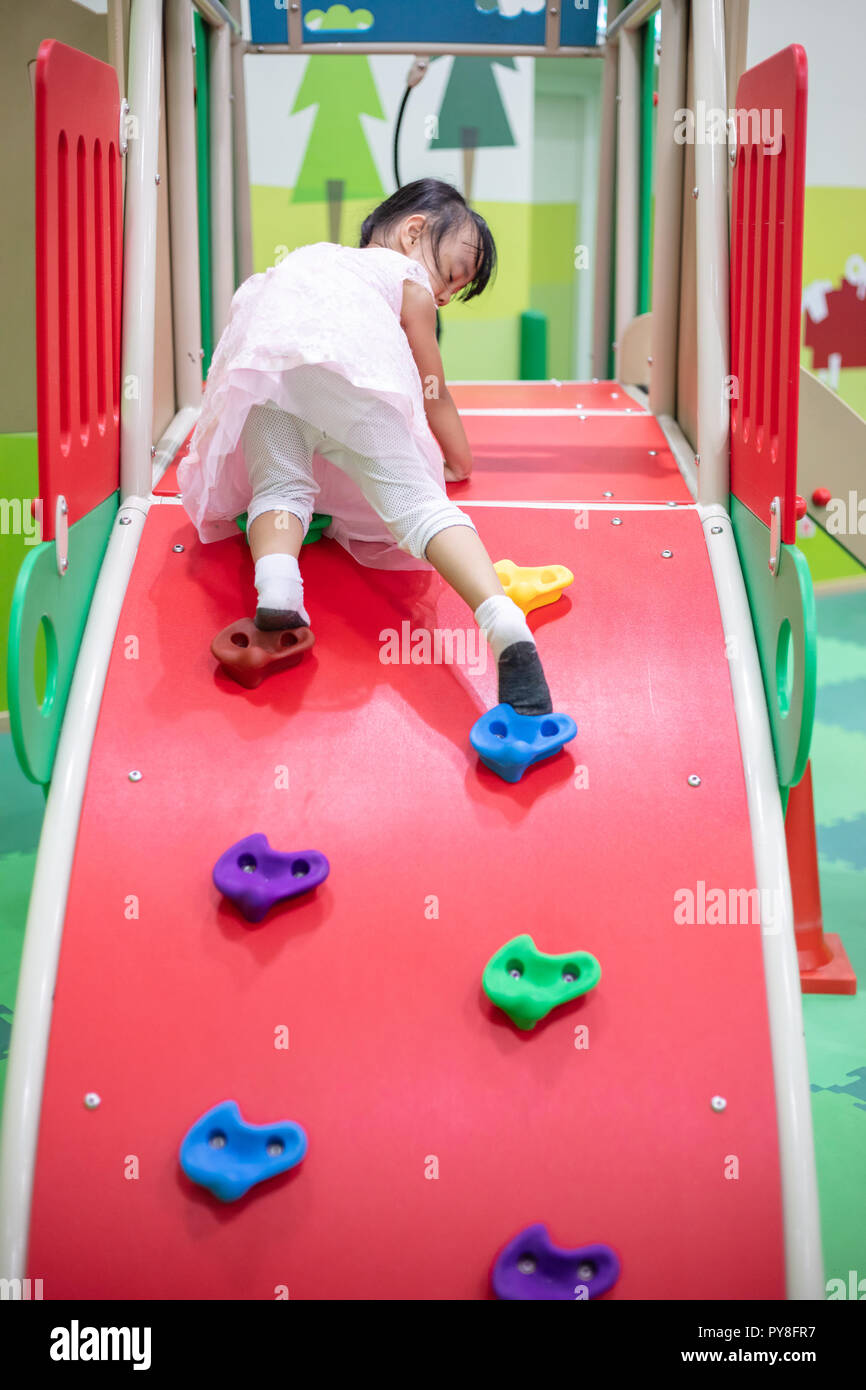 Asian Chinese little Girl playing at mini rock climbing wall at Indoor ...