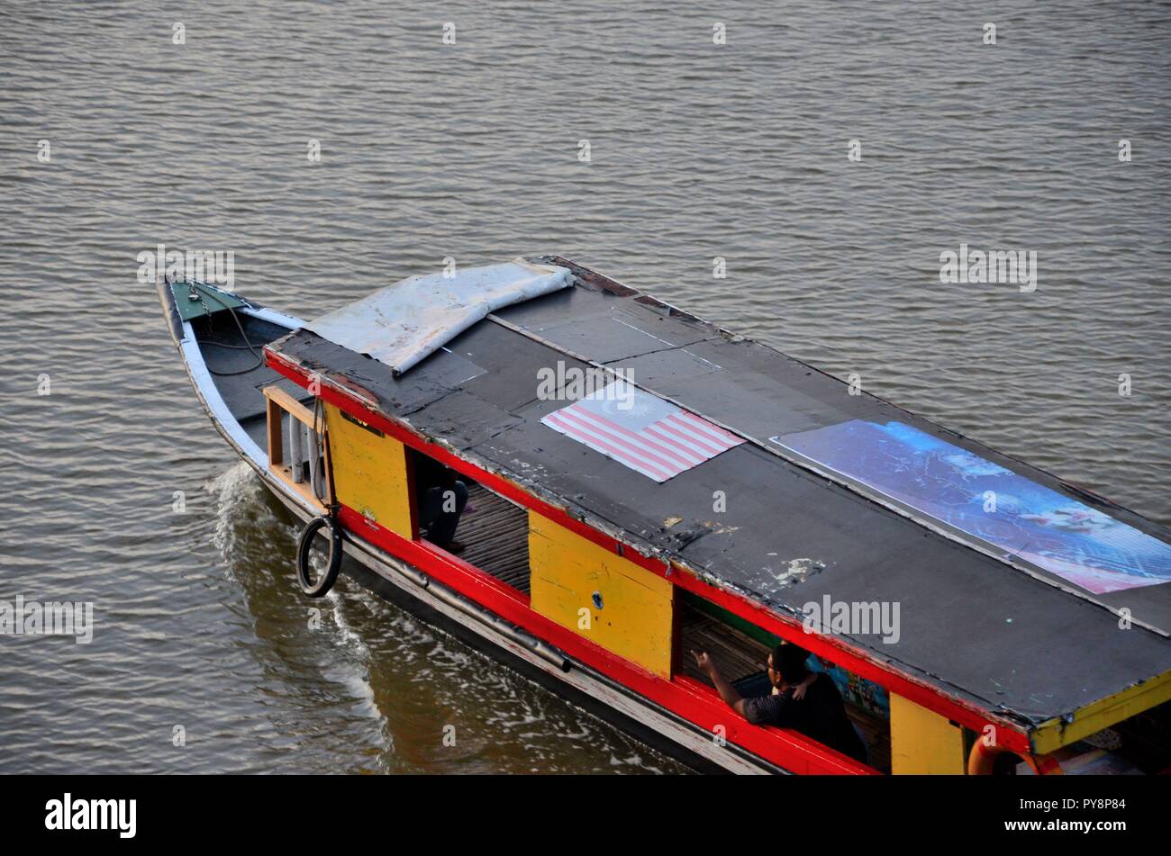 A sampan river ferry boat with Malaysia flag on Sarawak River Kuching ...