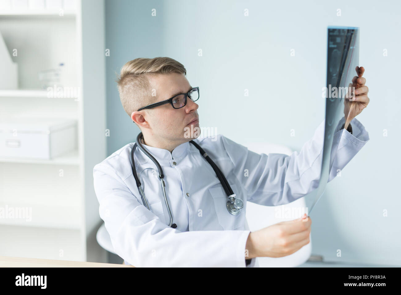 Medicine, working and people concept - doctor sitting at the table and ...