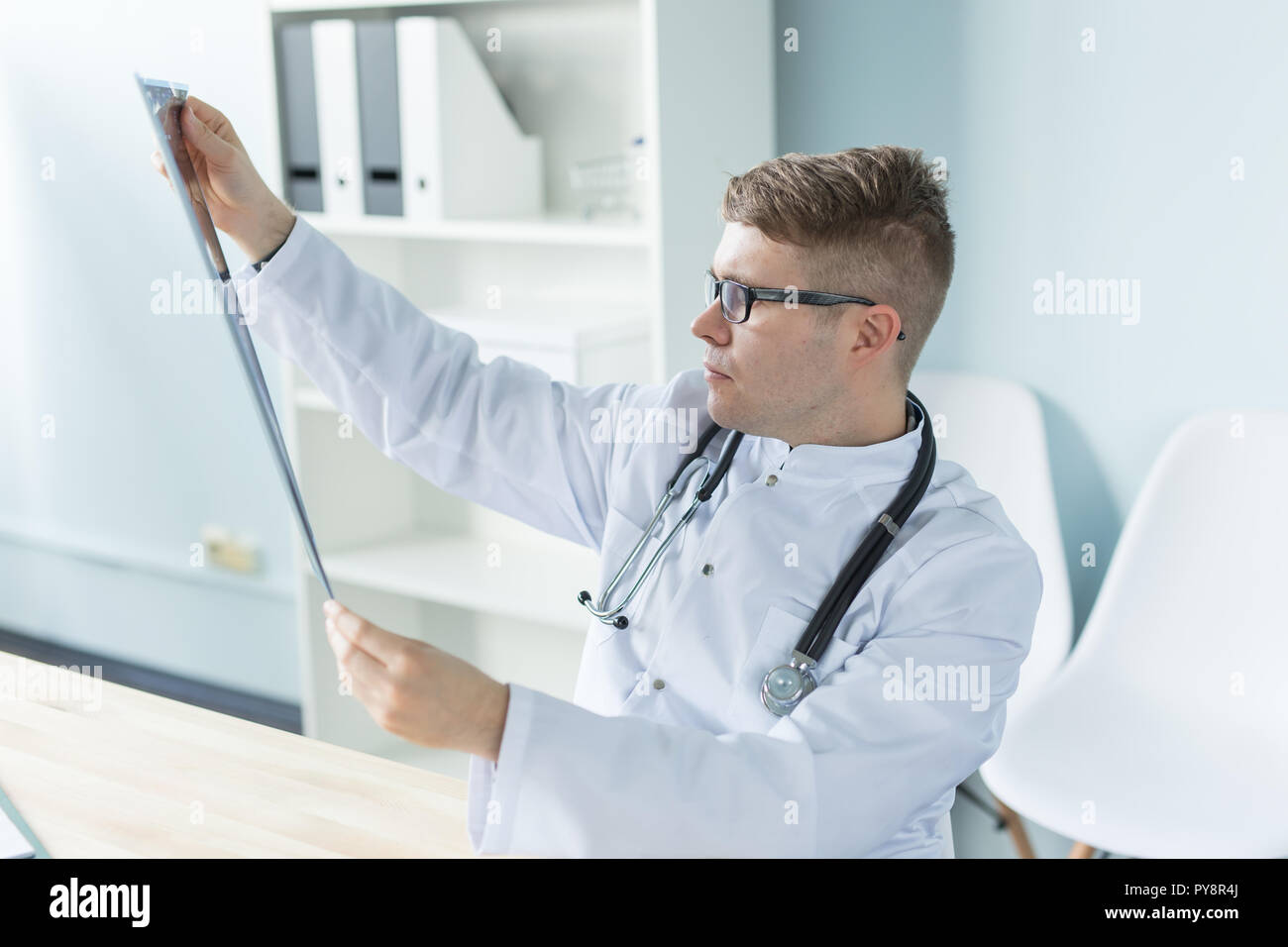 Medicine, working and people concept - doctor sitting at the table and ...