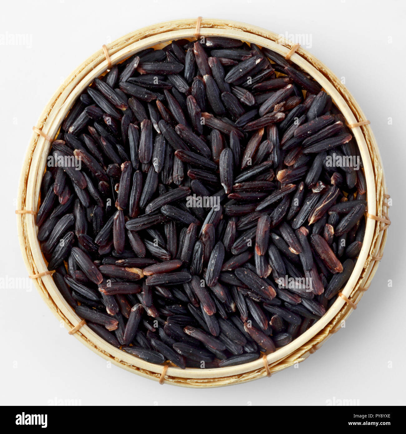 Thai black jasmine rice (Riceberry)in bamboo basket isolated on white ...