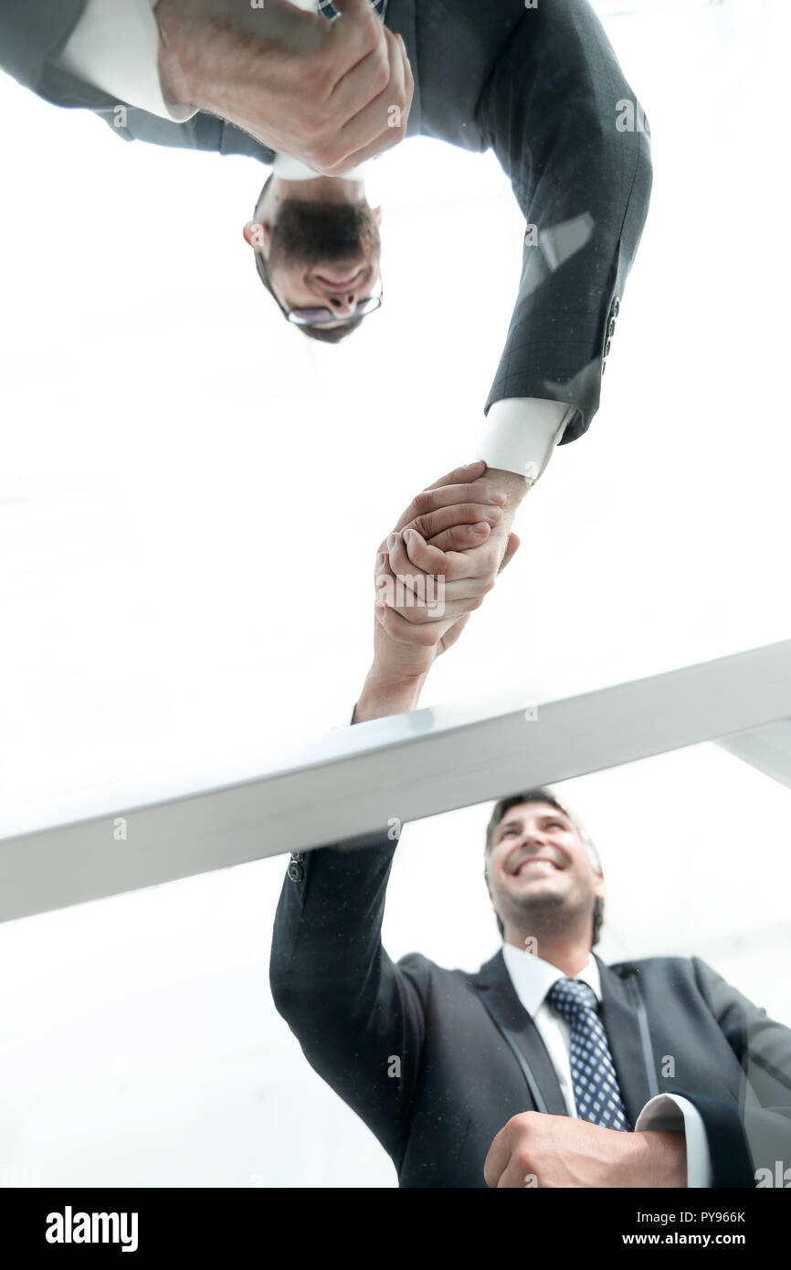 View from below. From behind the glass. Handshake of business partners ...