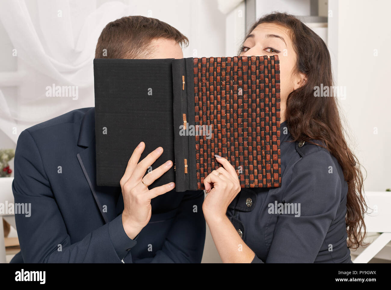 romantic couple drinking tea with cookies, kissing behind photo album ...