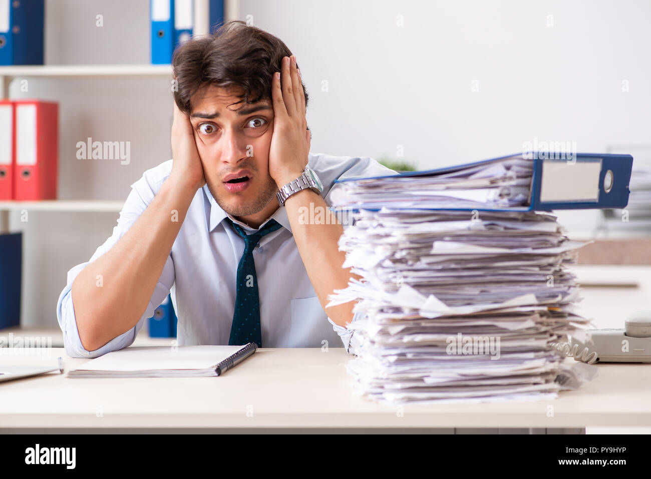 Overloaded busy employee with too much work and paperwork Stock Photo ...