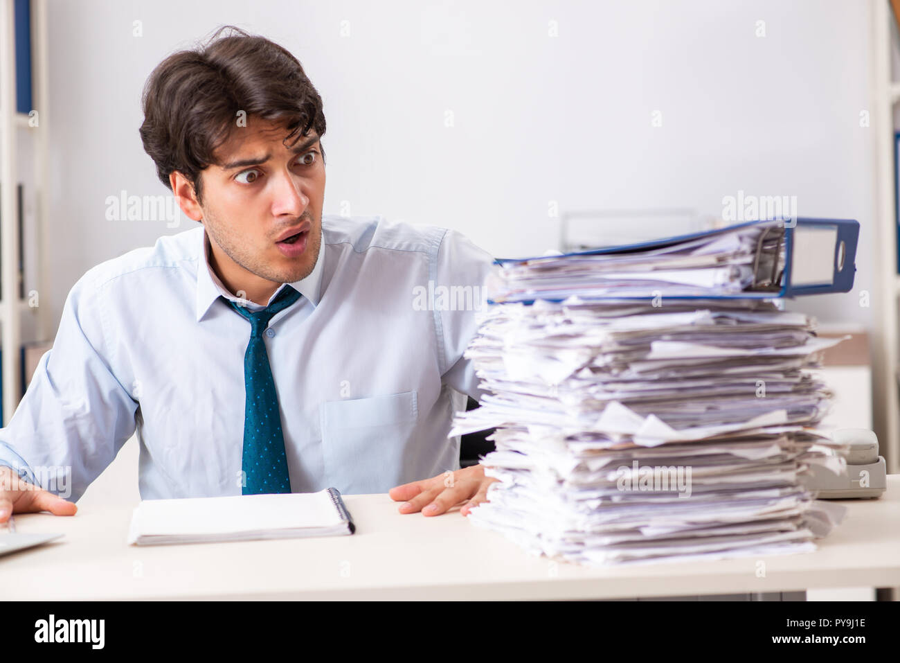 Overloaded busy employee with too much work and paperwork Stock Photo ...