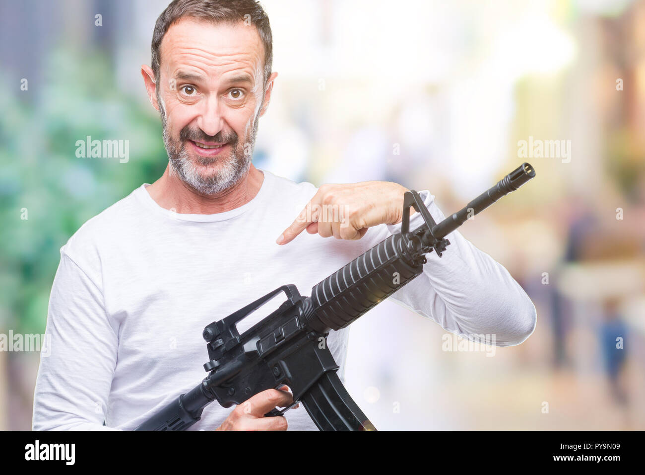 Middle age senior hoary criminal man holding gun weapon over isolated ...