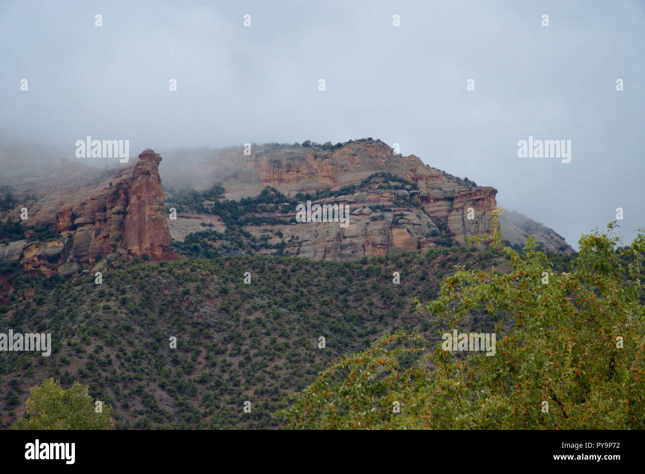 The Colorado National Monument with a gloomy grey sky. There is a red ...