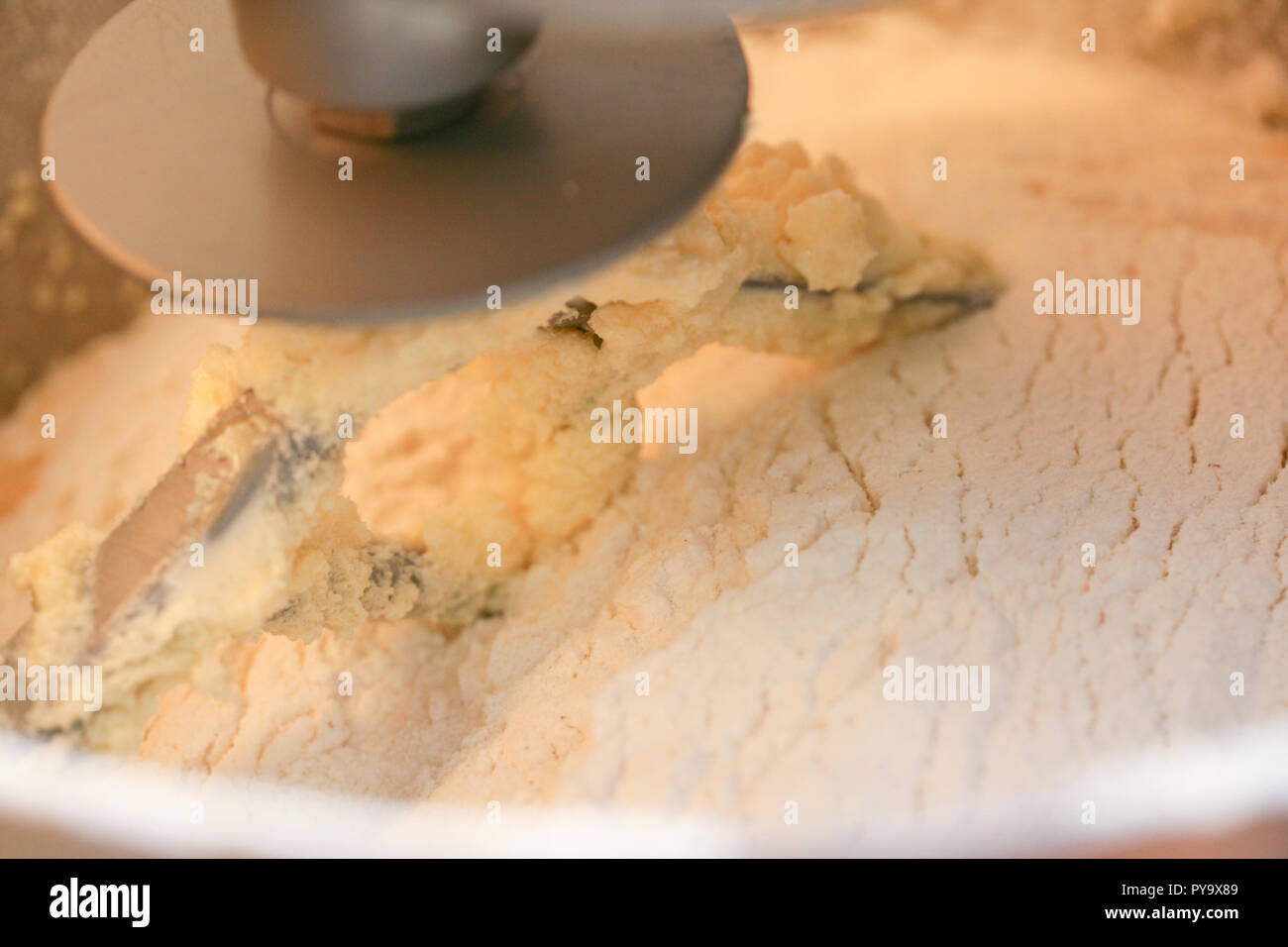 Mixing in the flour to make a batter for cakes Stock Photo - Alamy