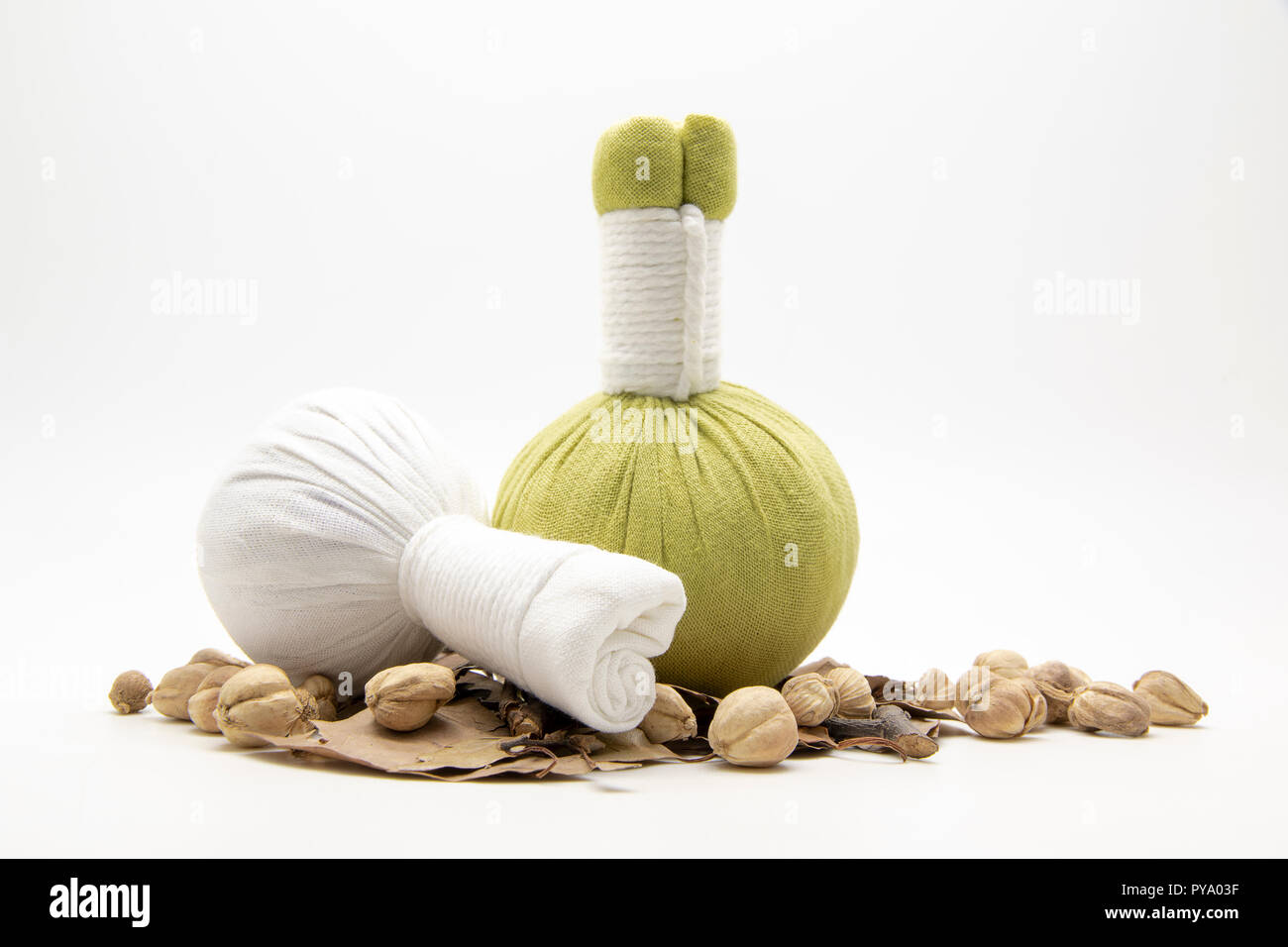 Green compress ball, White compress ball and herbs on white background ...
