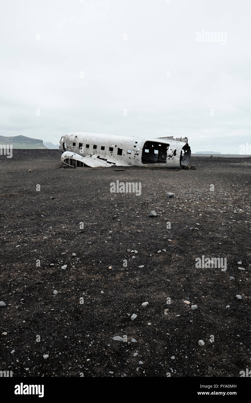 The remote and eerie plane wreckage in the black sand plain desert of ...