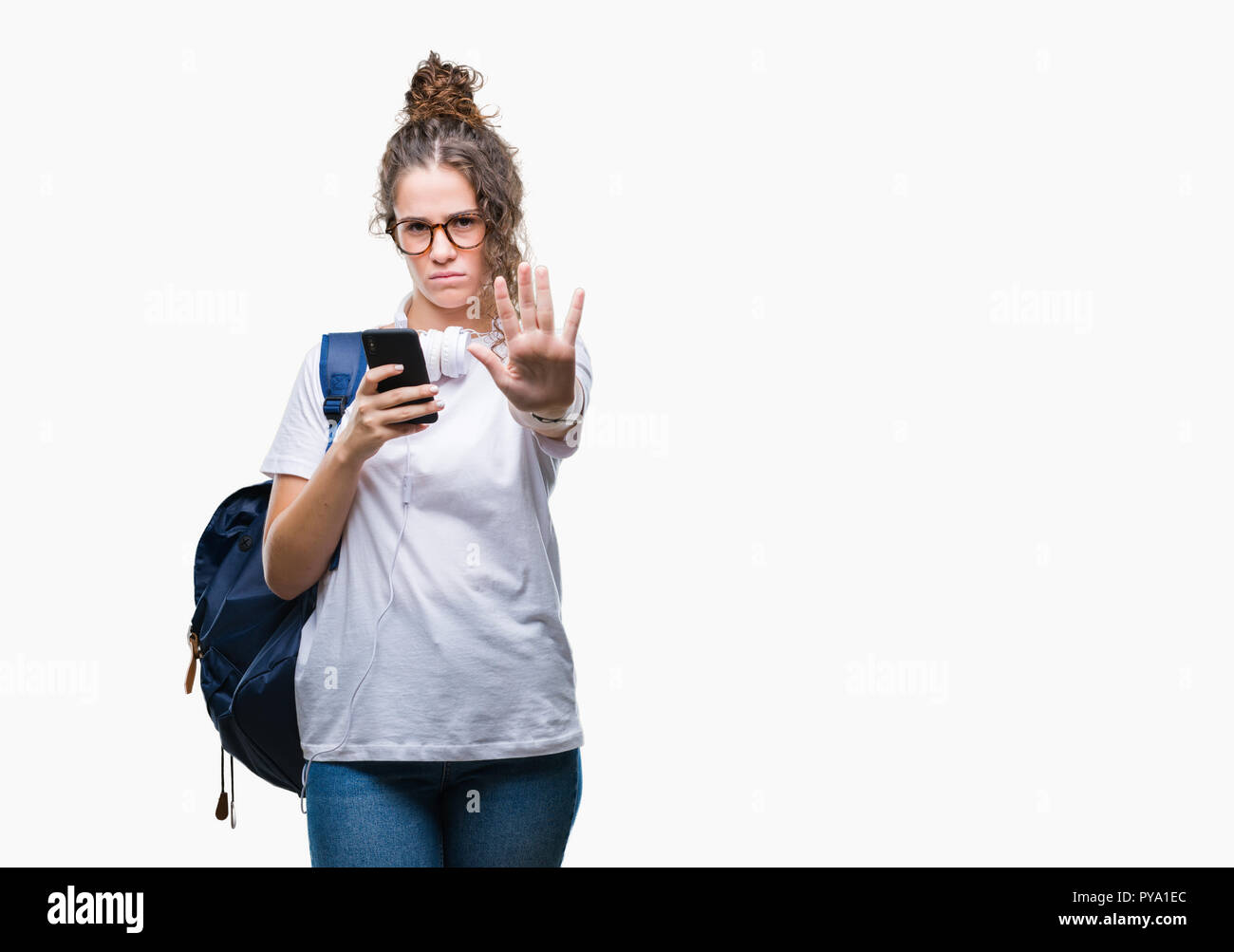 Young brunette student girl wearing backpack, headphones and smartphone ...