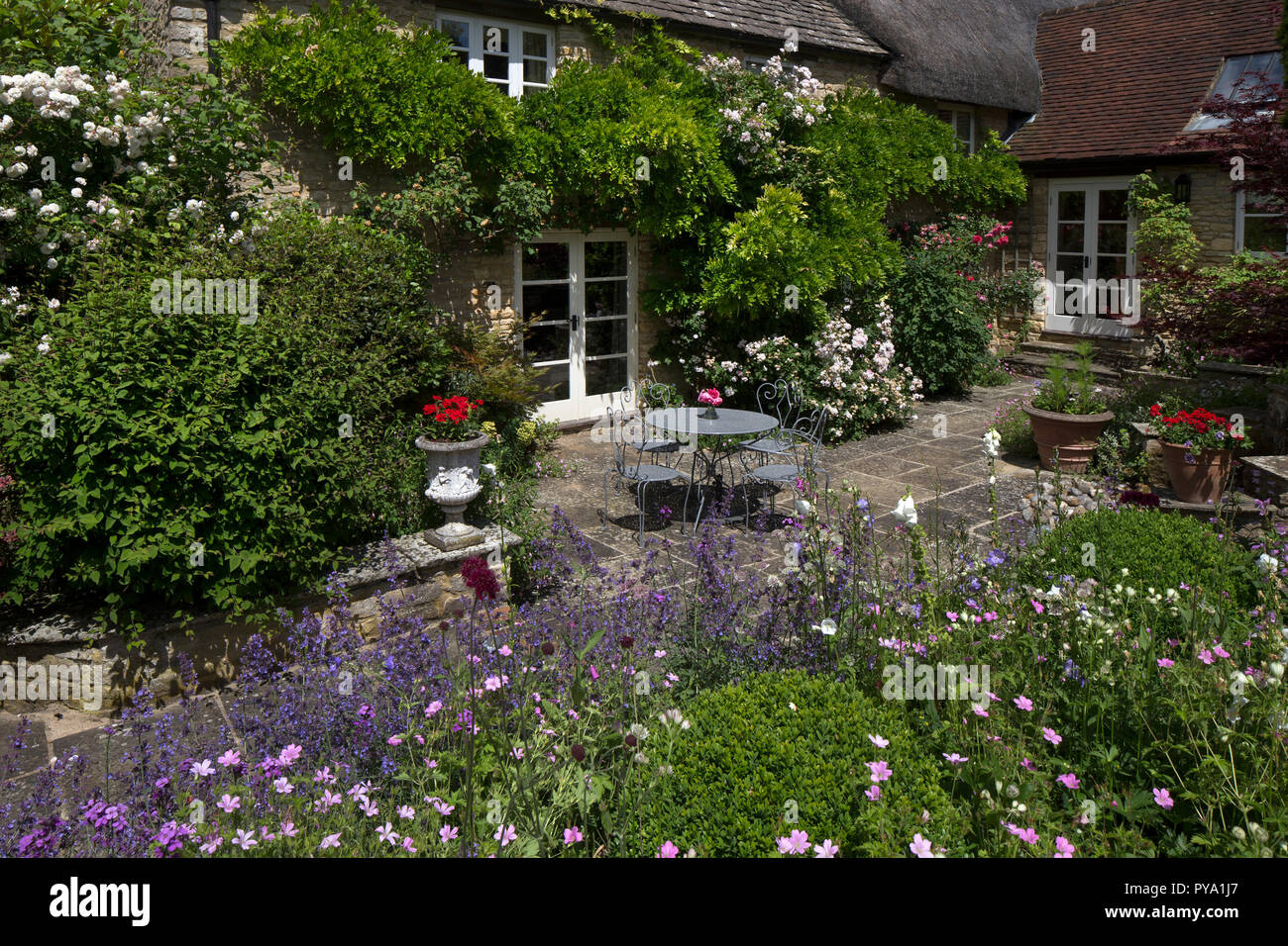 metal table and chairs on patio in English Garden,England,Europe Stock ...