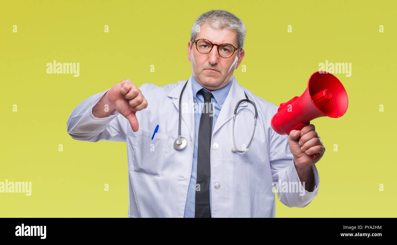 Handsome senior doctor man yelling through megaphone over isolated ...