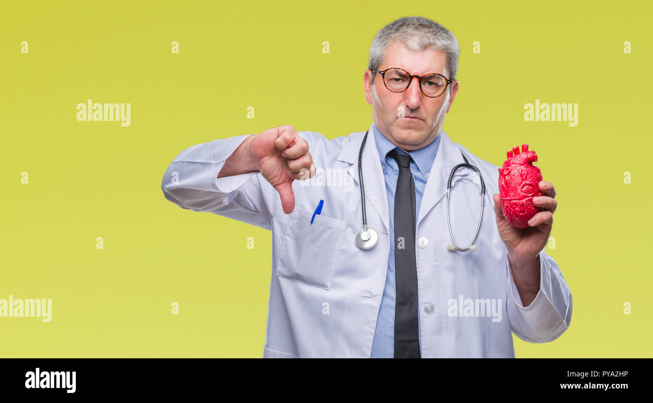 Handsome senior cardiologist doctor man holding heart over isolated ...