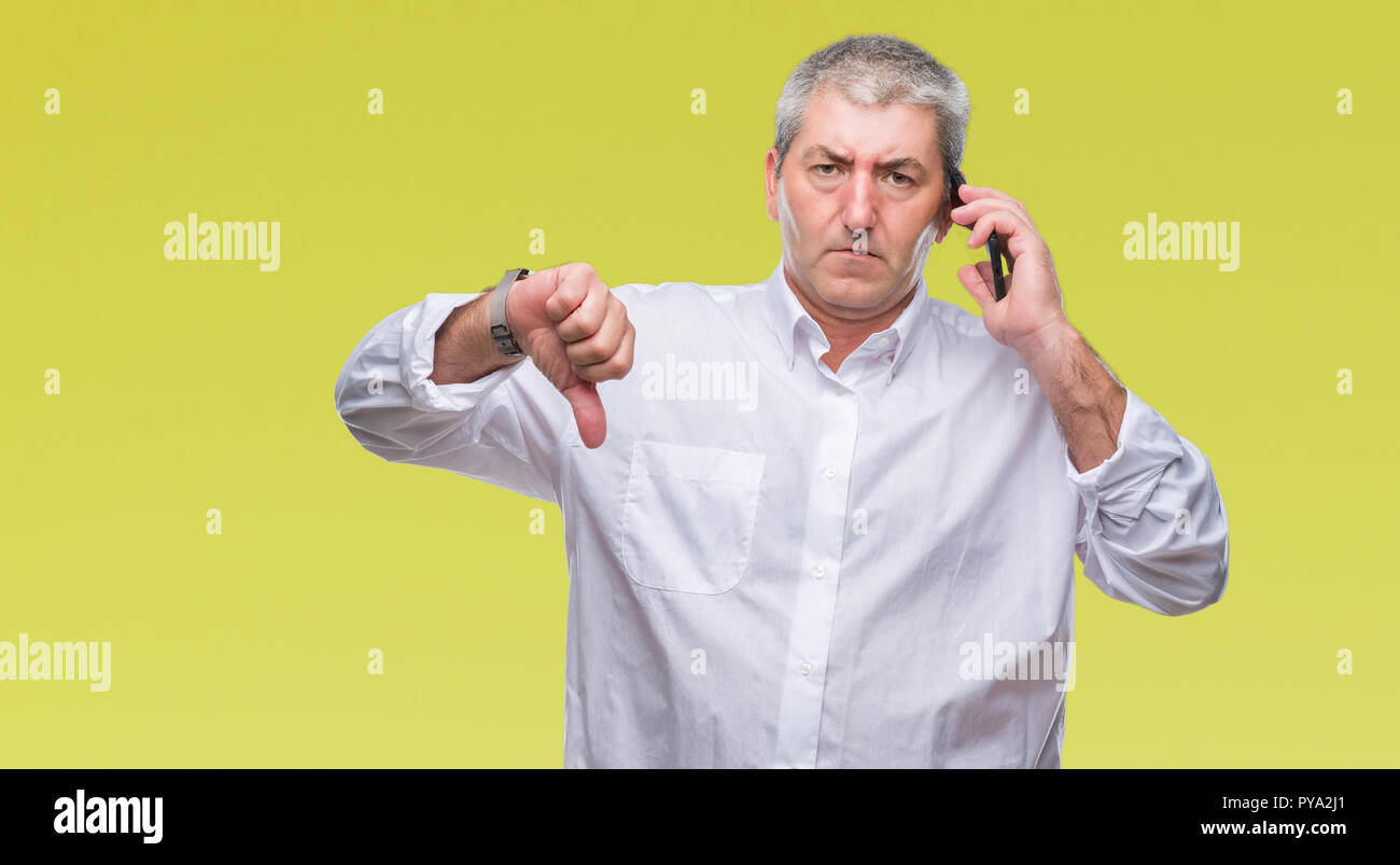 Handsome senior man talking on smartphone over isolated background with ...
