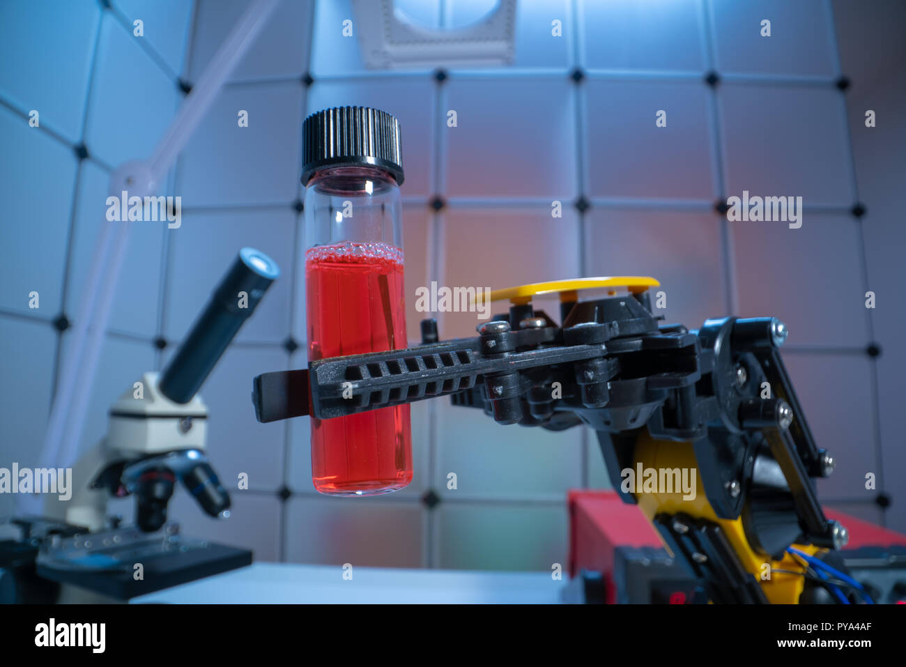 Test tube in robot arm. robot manipulates chemical tubes in the ...