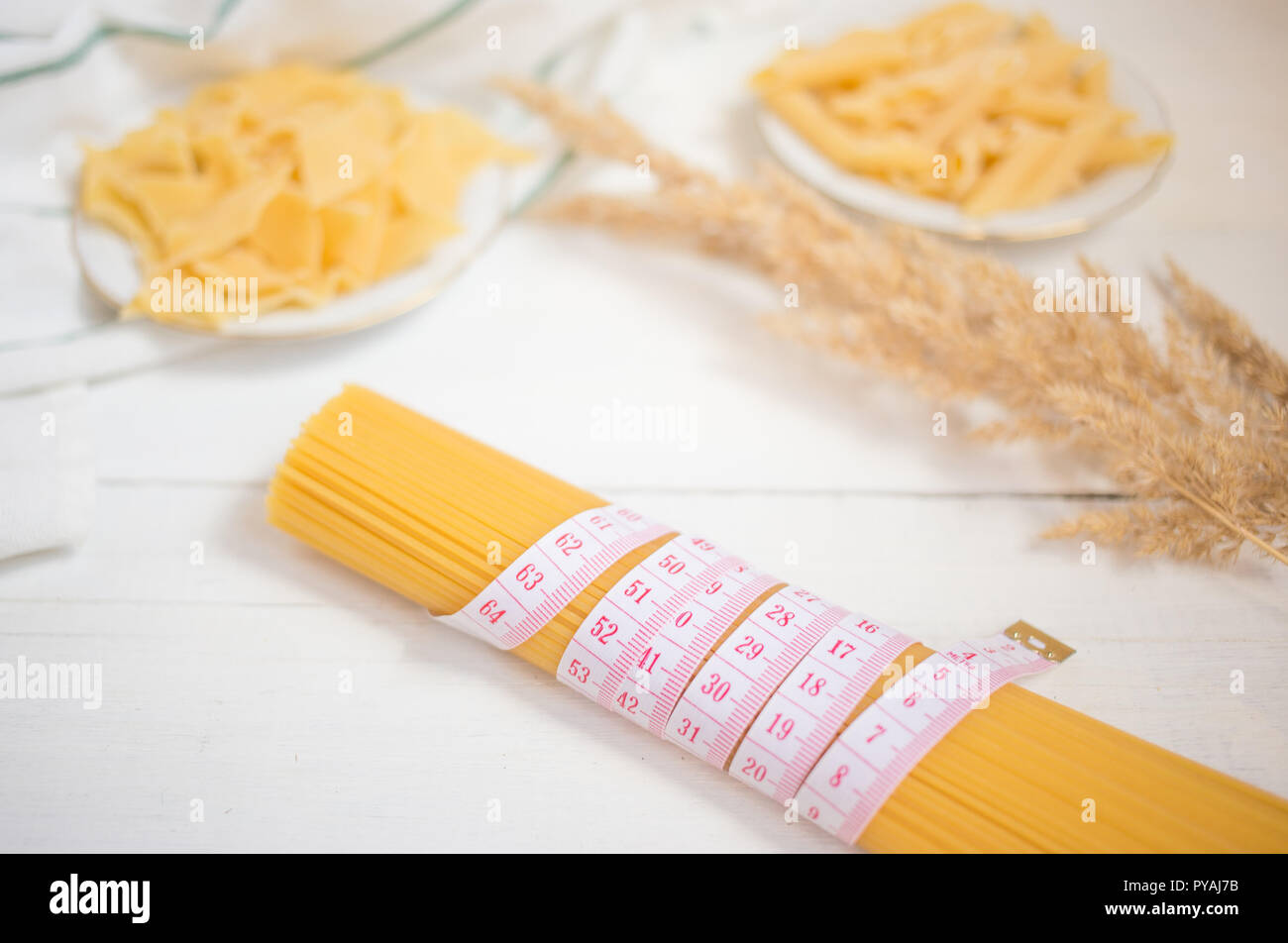 Measuring tape with bunch of uncooked Italian pasta spaghetti ...