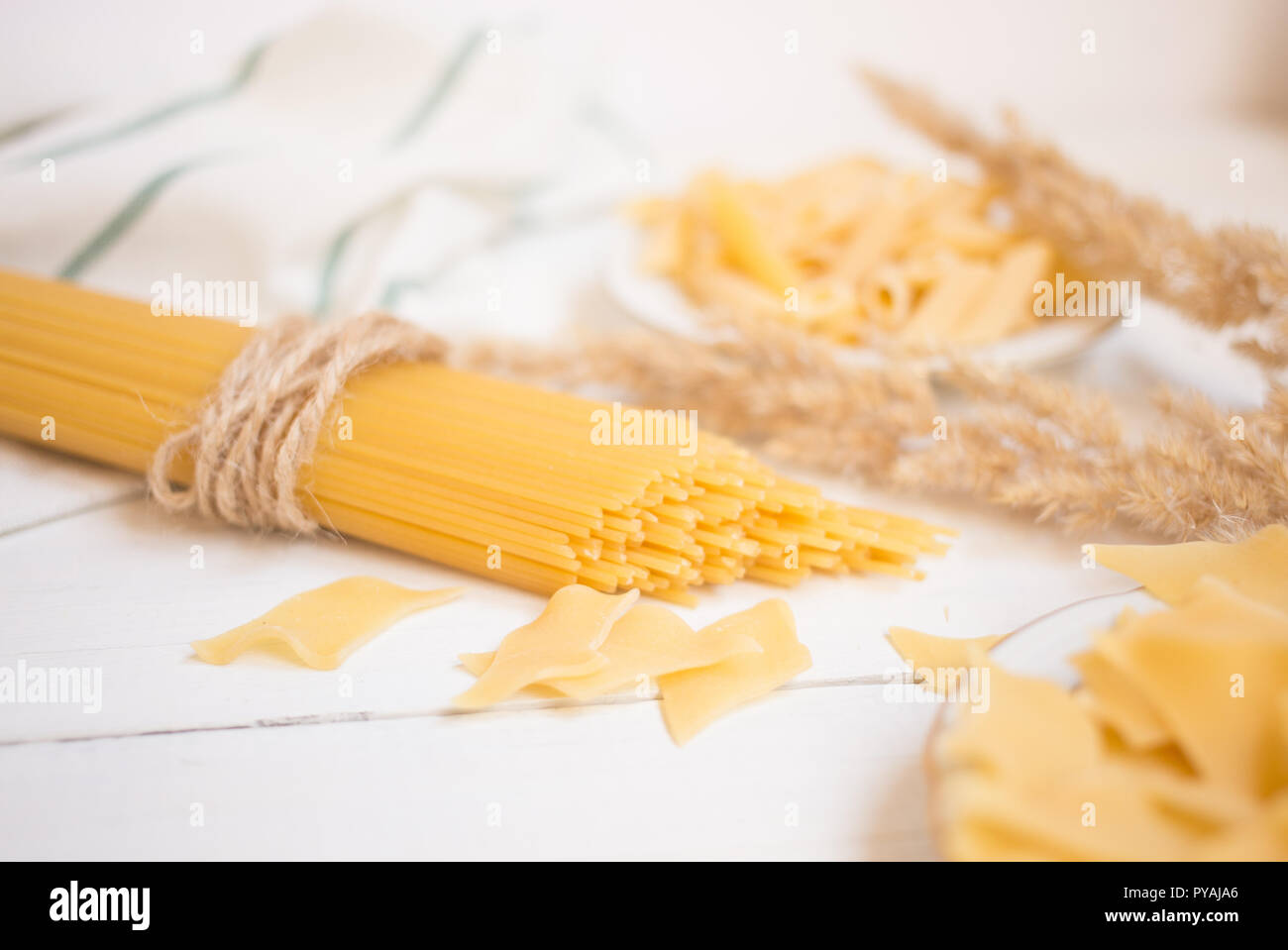 varieties of pasta on a white wooden table, spaghetti, Penne ...
