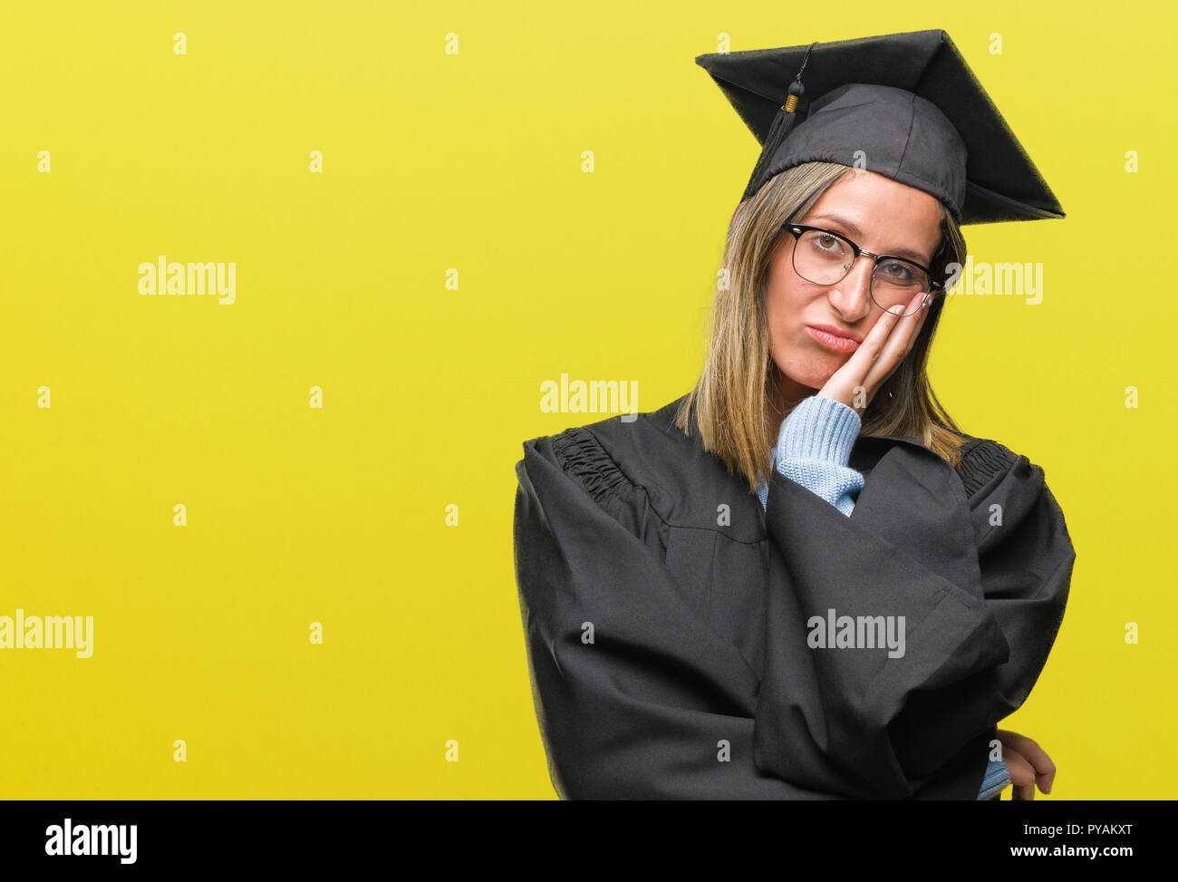 Young beautiful woman wearing graduated uniform over isolated ...